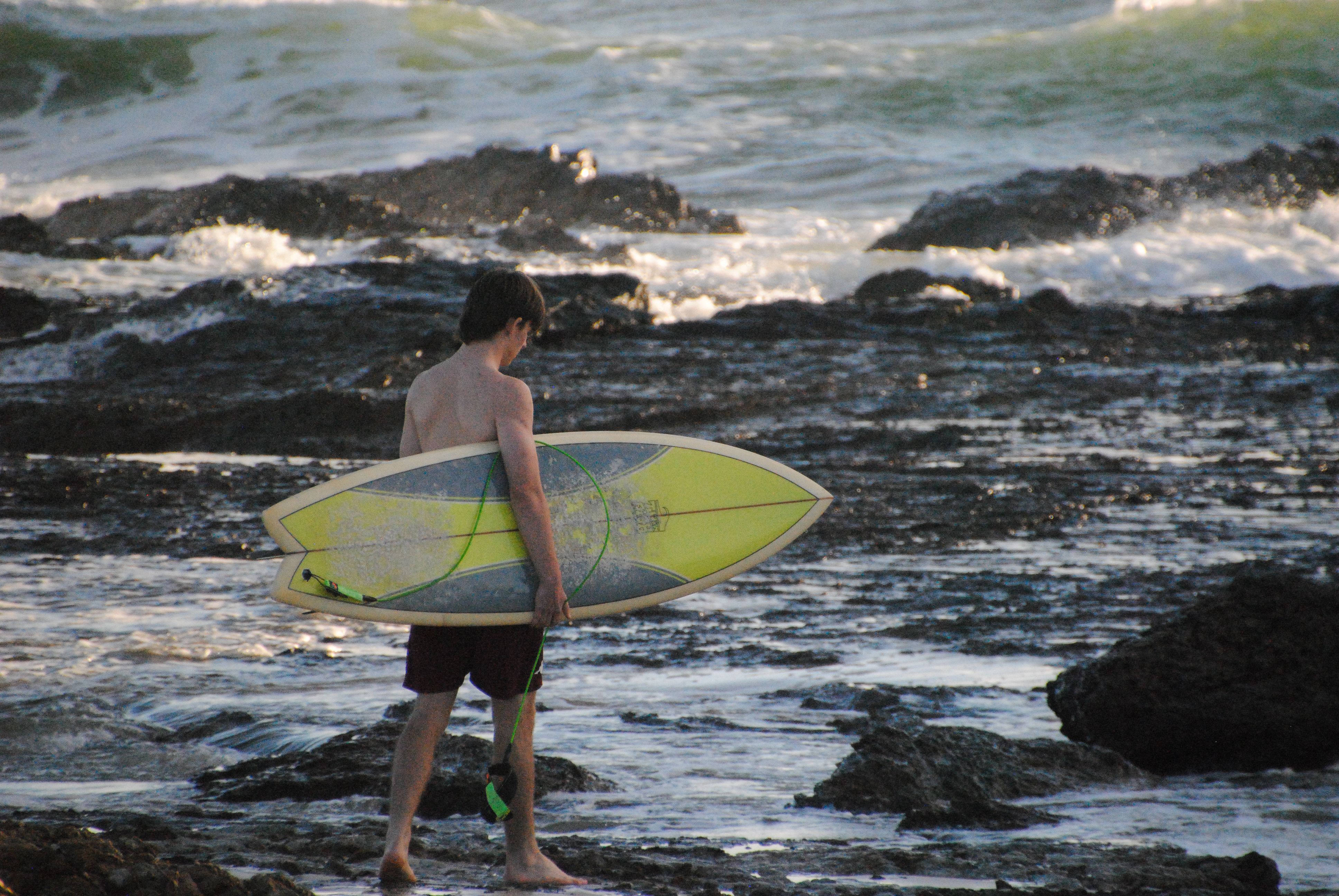 Photo of Man Carrying A Surfboard · Free Stock Photo
