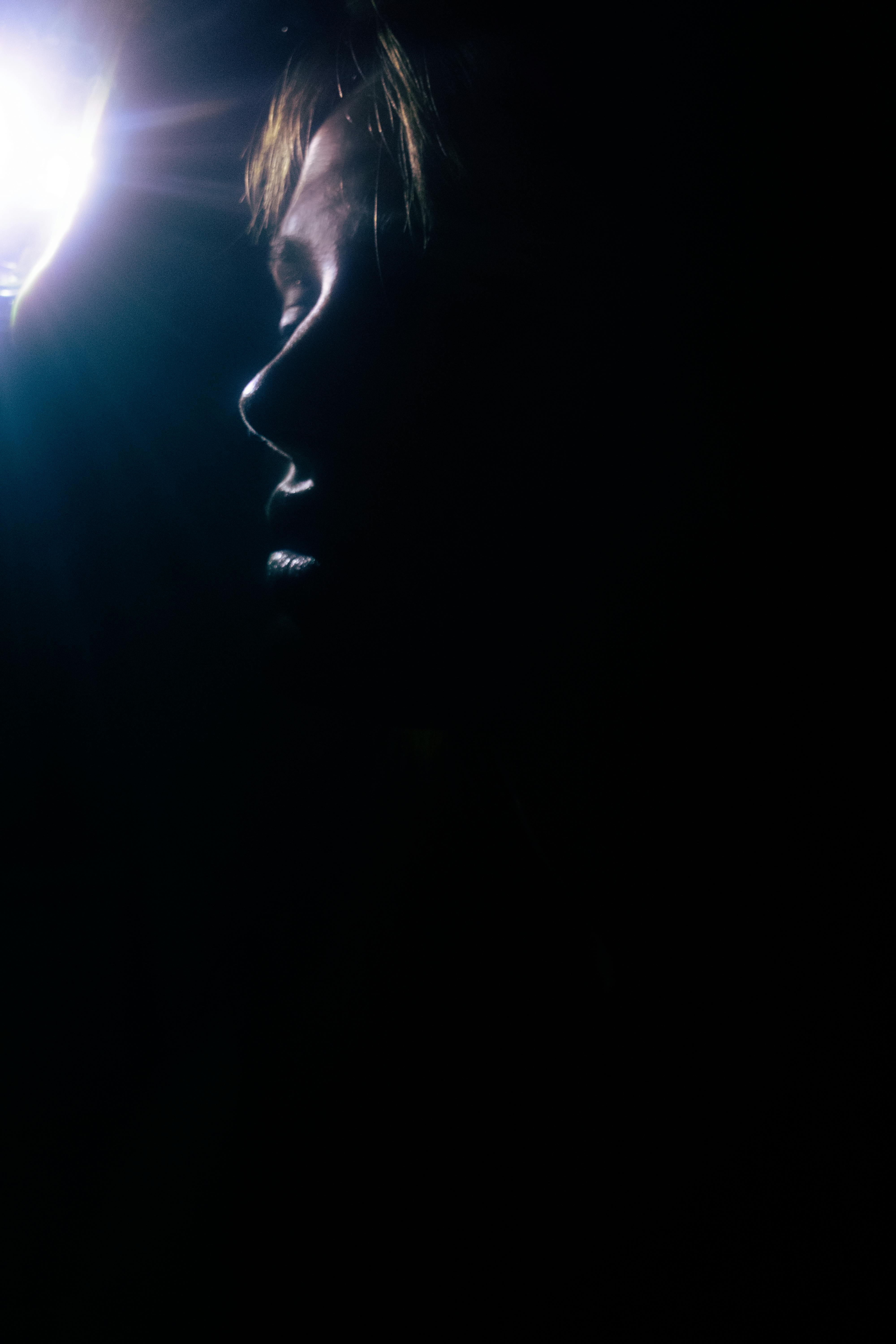 Contour of a Womans Face under a Light in Darkness · Free Stock Photo