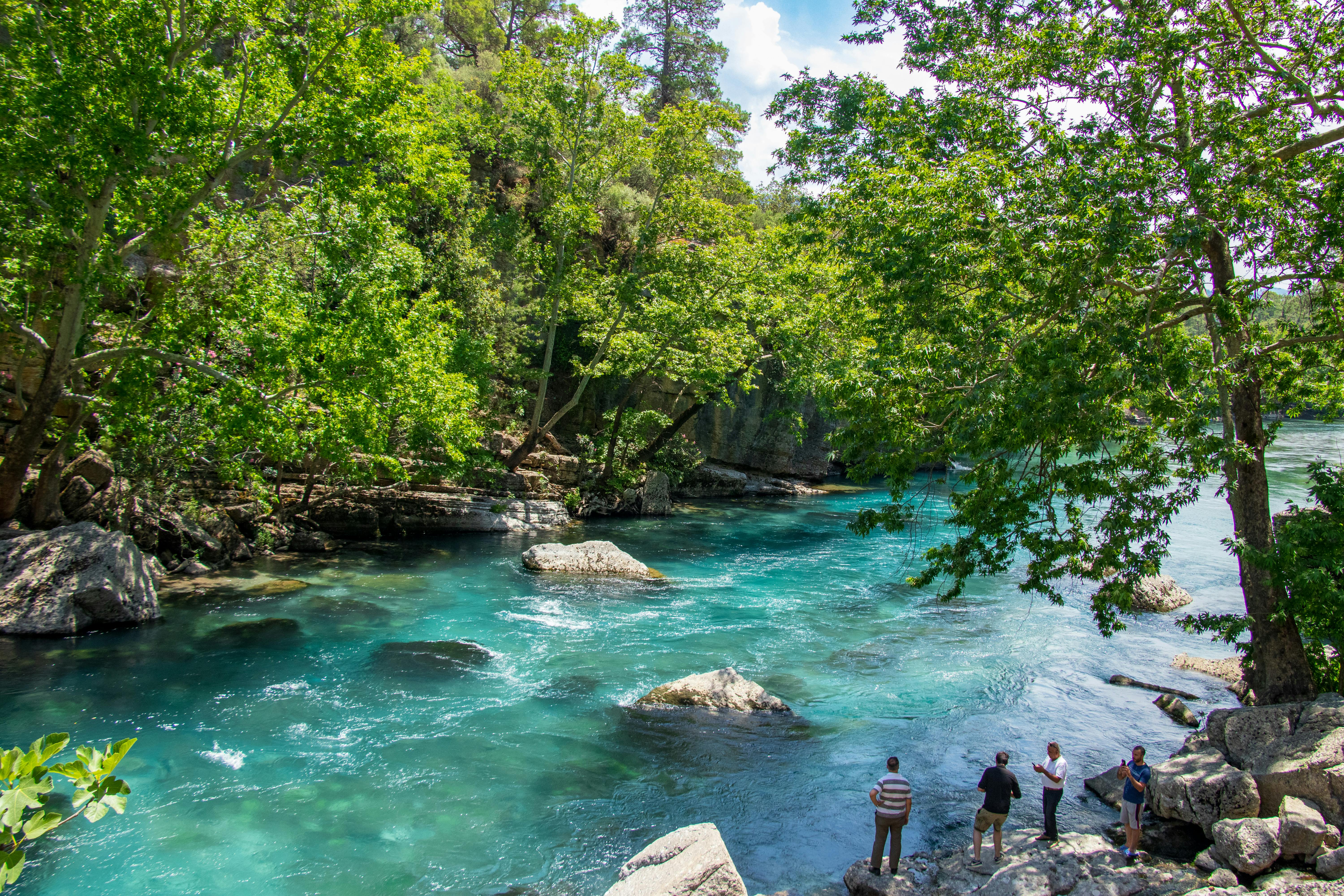 People Sightseeing Beside a Flowing River · Free Stock Photo