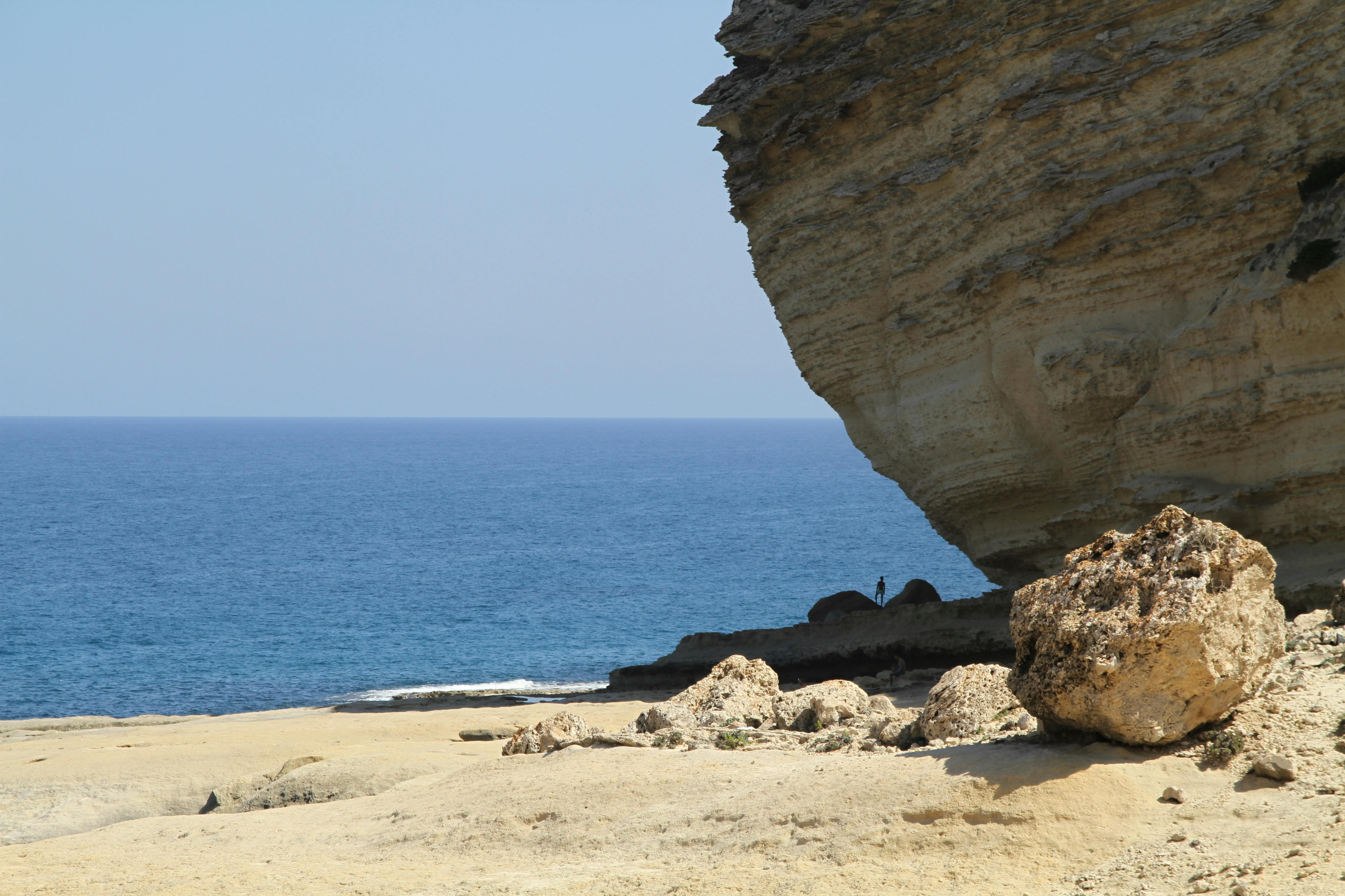 Person Standing under a Rock Formation · Free Stock Photo
