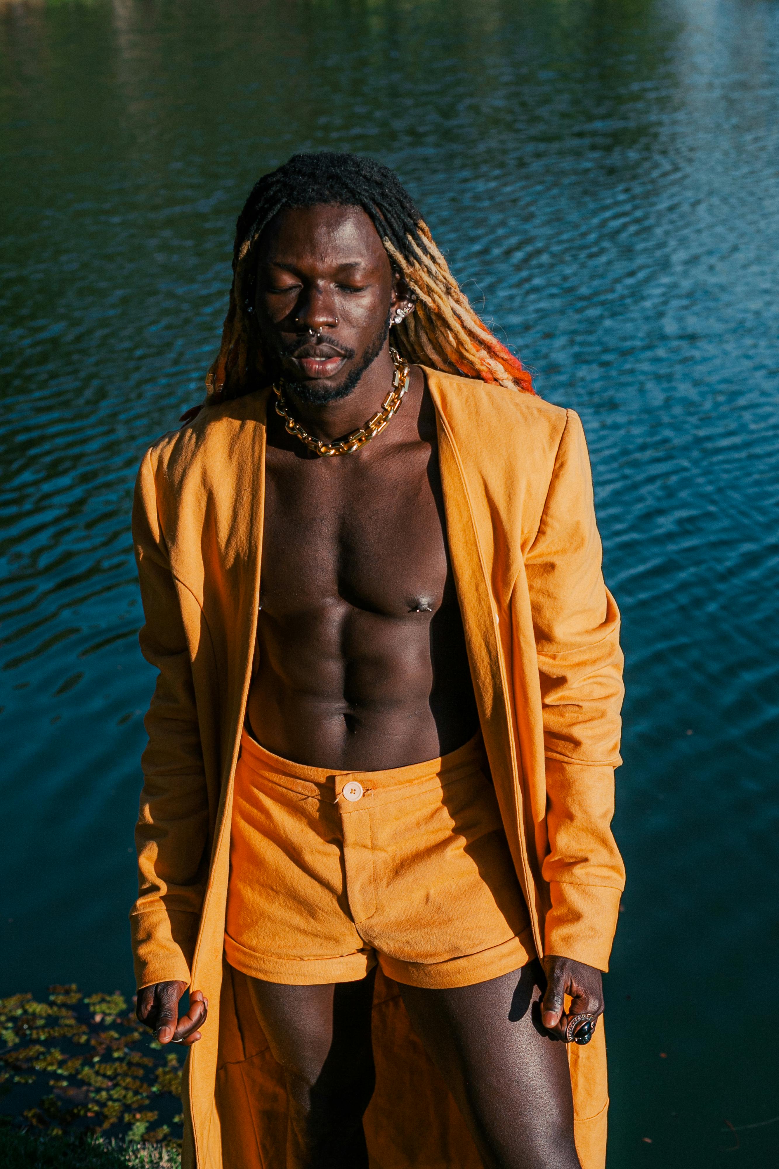 A Man with Dreadlocks Hair Wearing an Orange Coat · Free Stock Photo