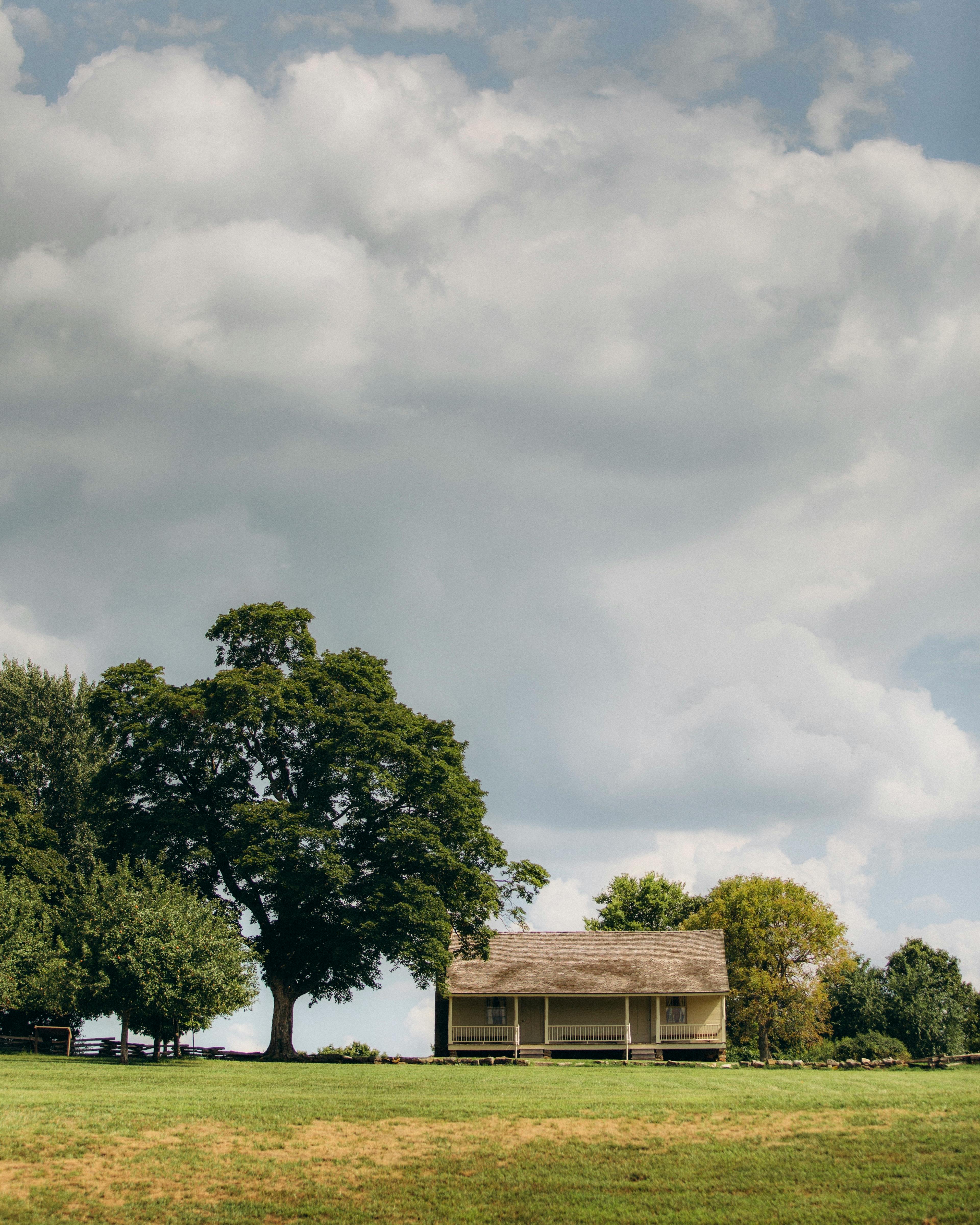 Brown House in the Middle of Green Open Field Surrounded With Trees ...