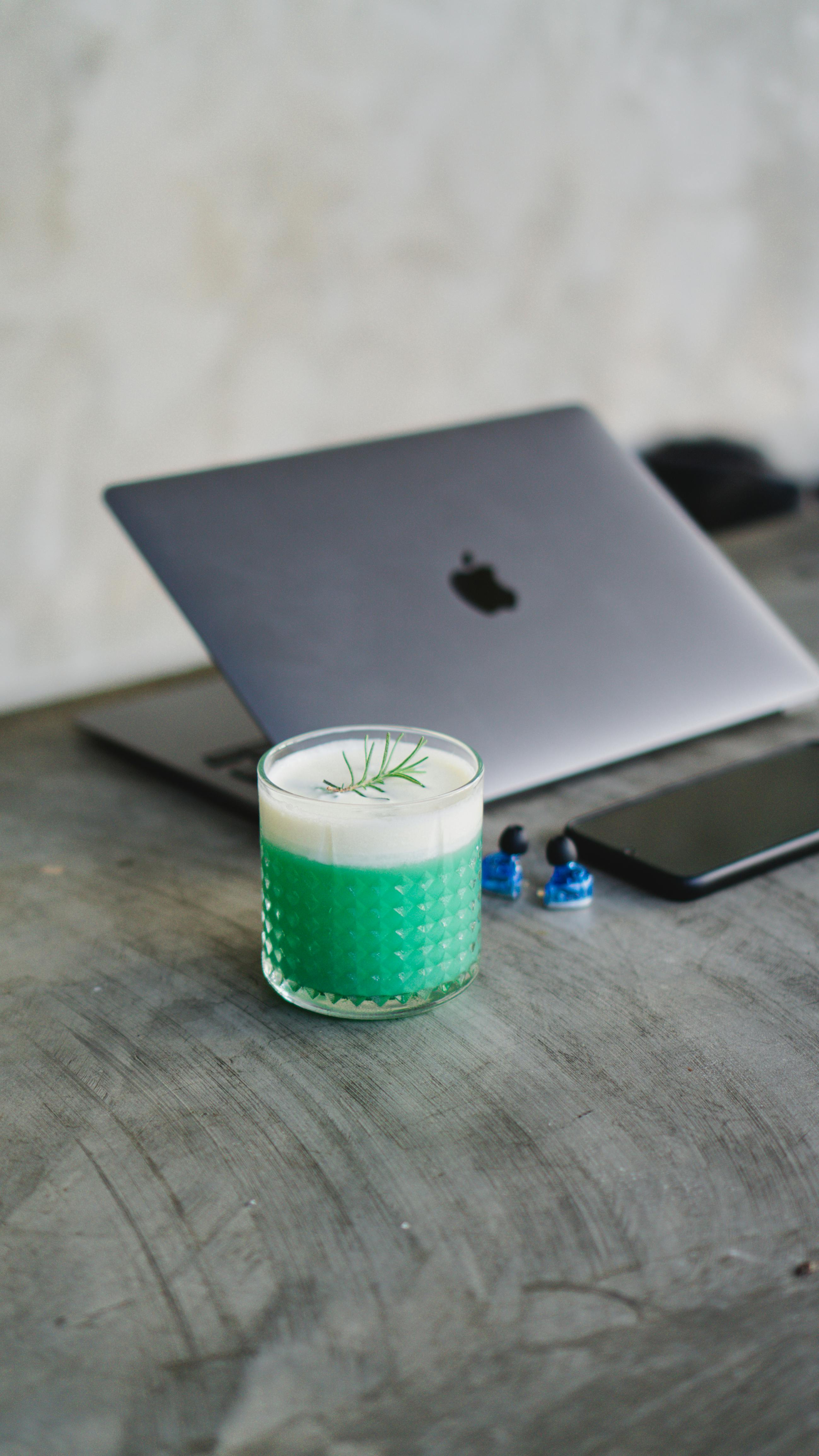 Cocktail Drink Beside a Laptop on Concrete Table · Free Stock Photo