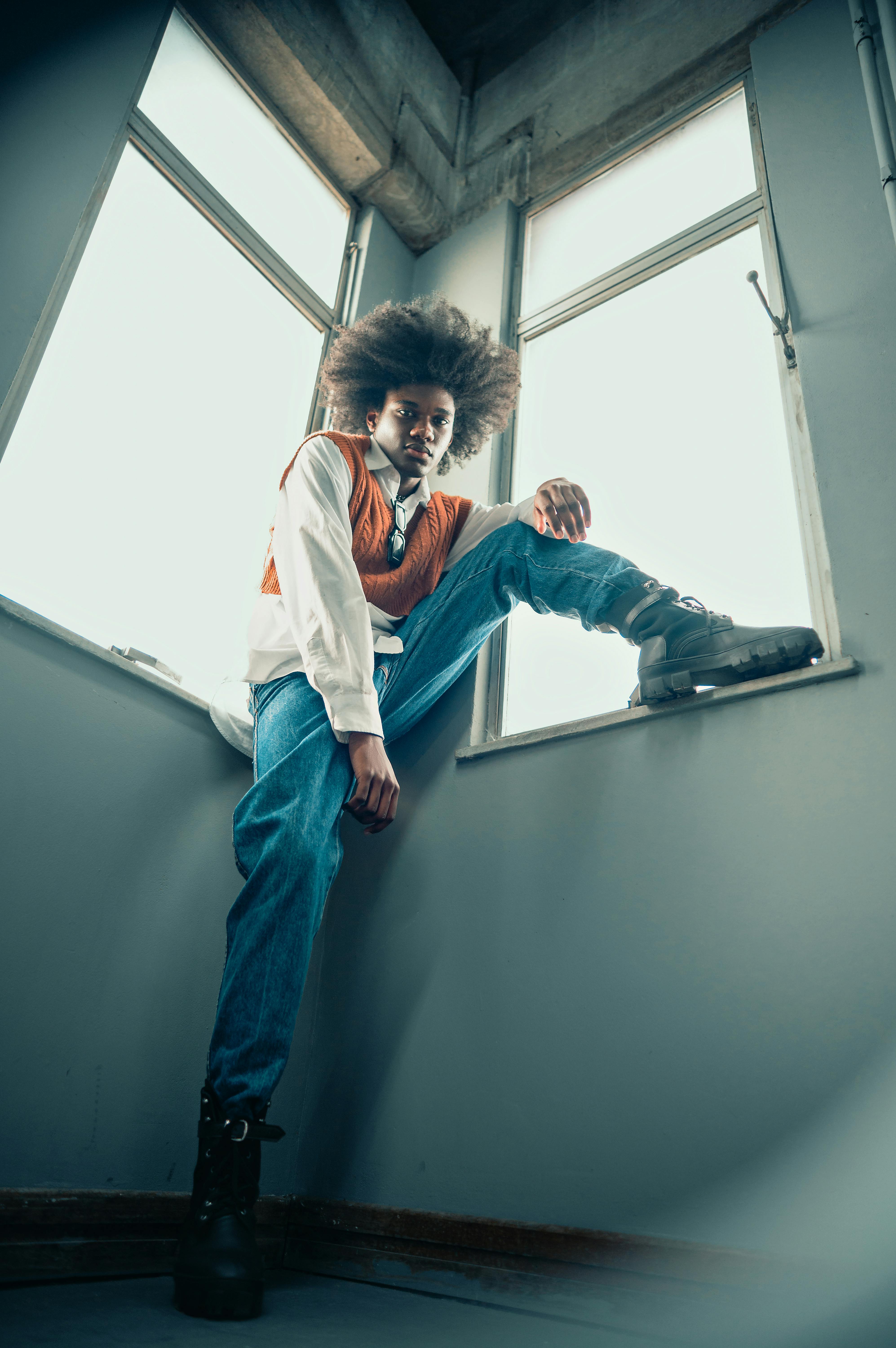 Portrait of Curly Haired Woman in Jeans Crouching · Free Stock Photo