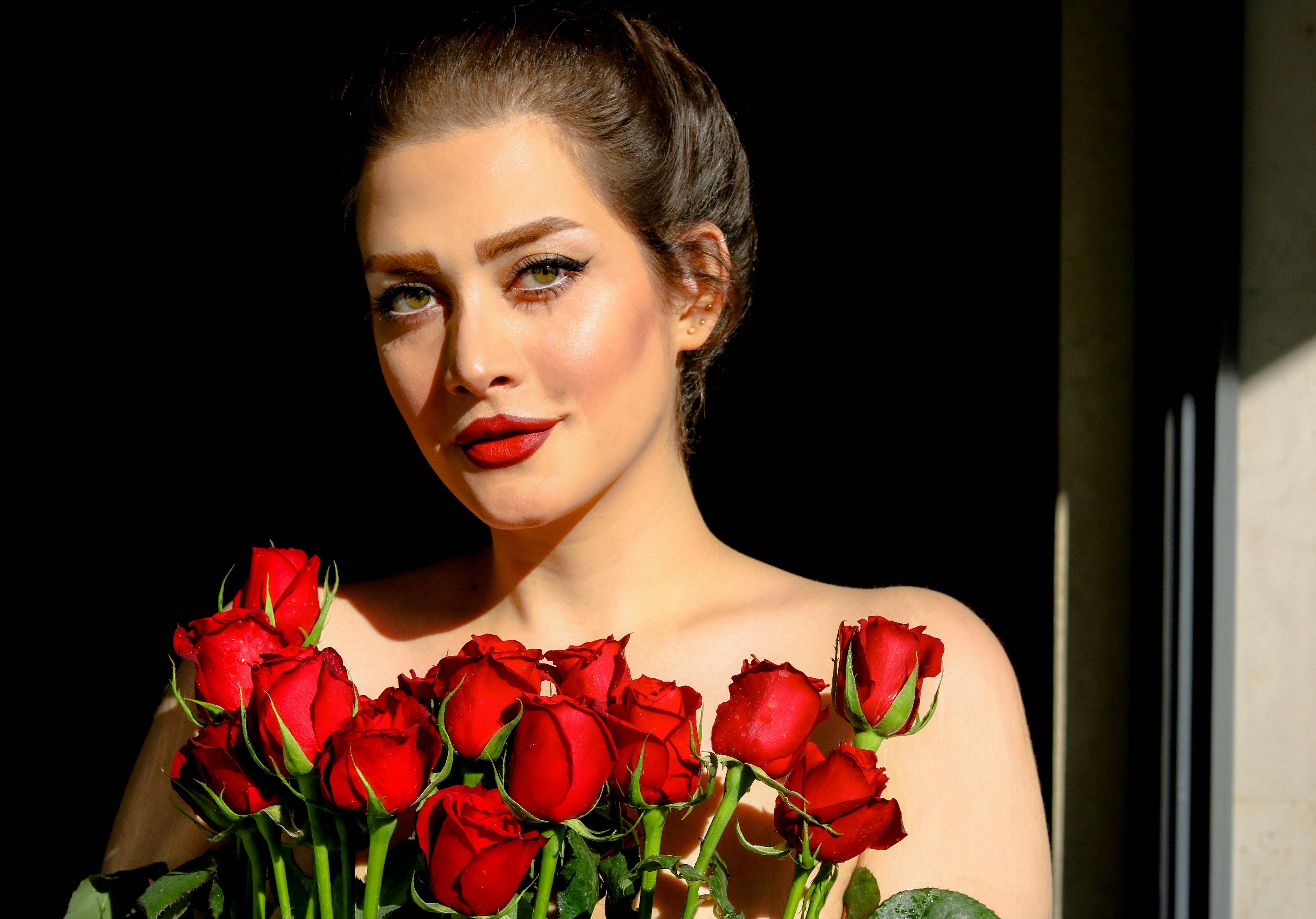 Close-Up Shot of a Beautiful Woman Holding Red Roses · Free Stock Photo