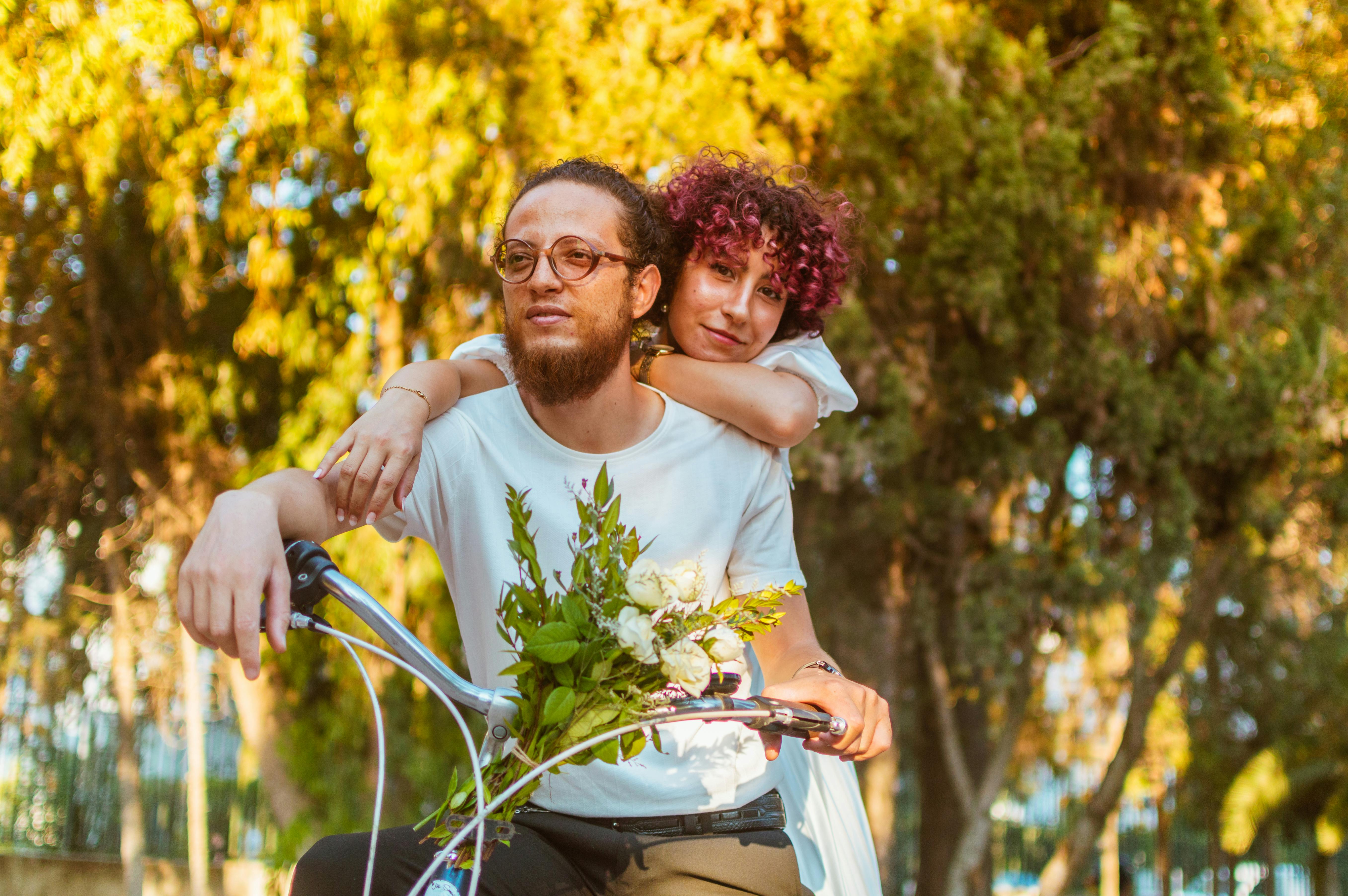Close-Up Shot of a Romantic Couple Riding a Bicycle · Free Stock Photo