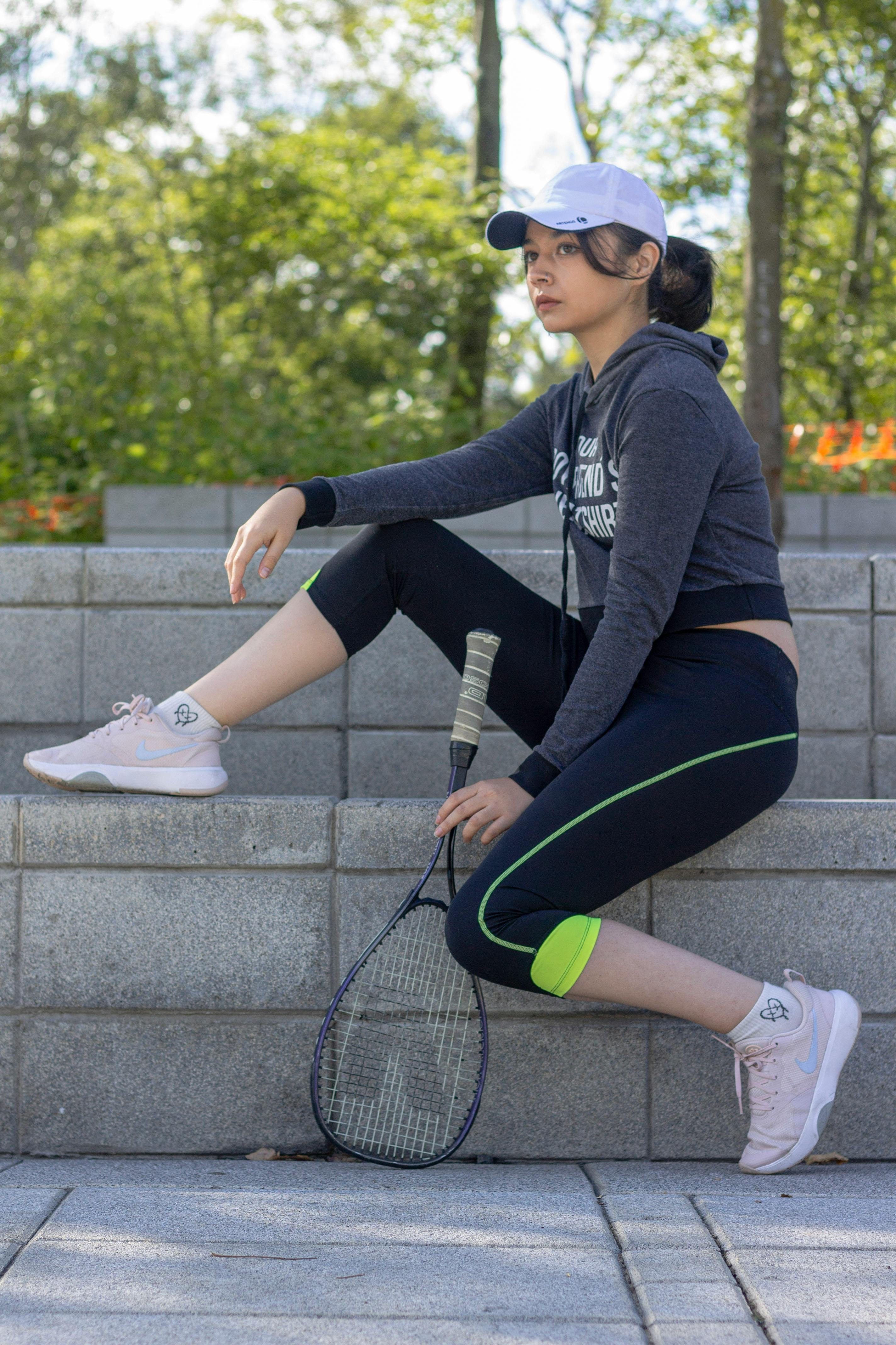 A Woman Sitting with a Tennis Racket · Free Stock Photo