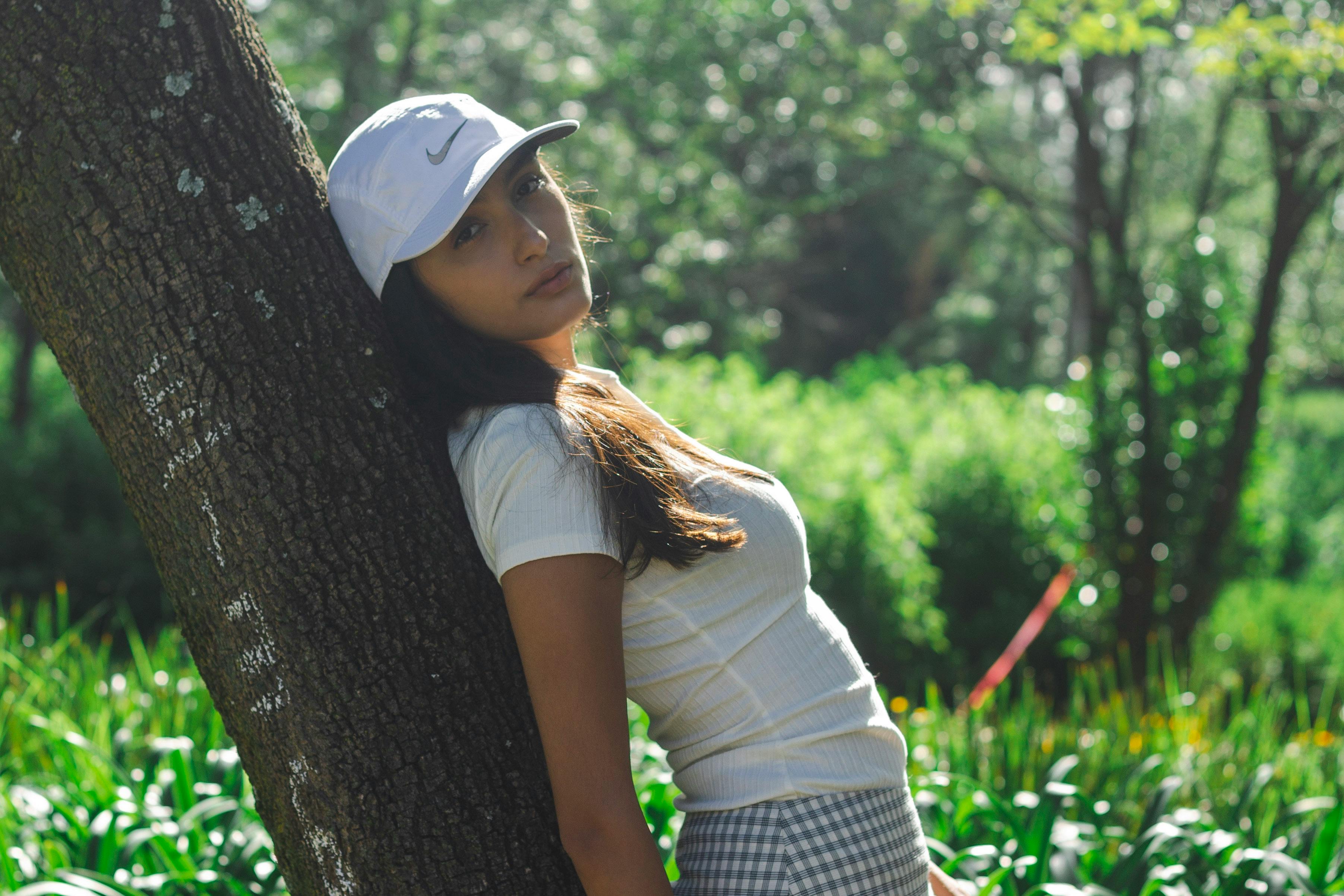 Blonde Woman Wearing Beige Coat Leaning on Tree Trunk · Free Stock Photo