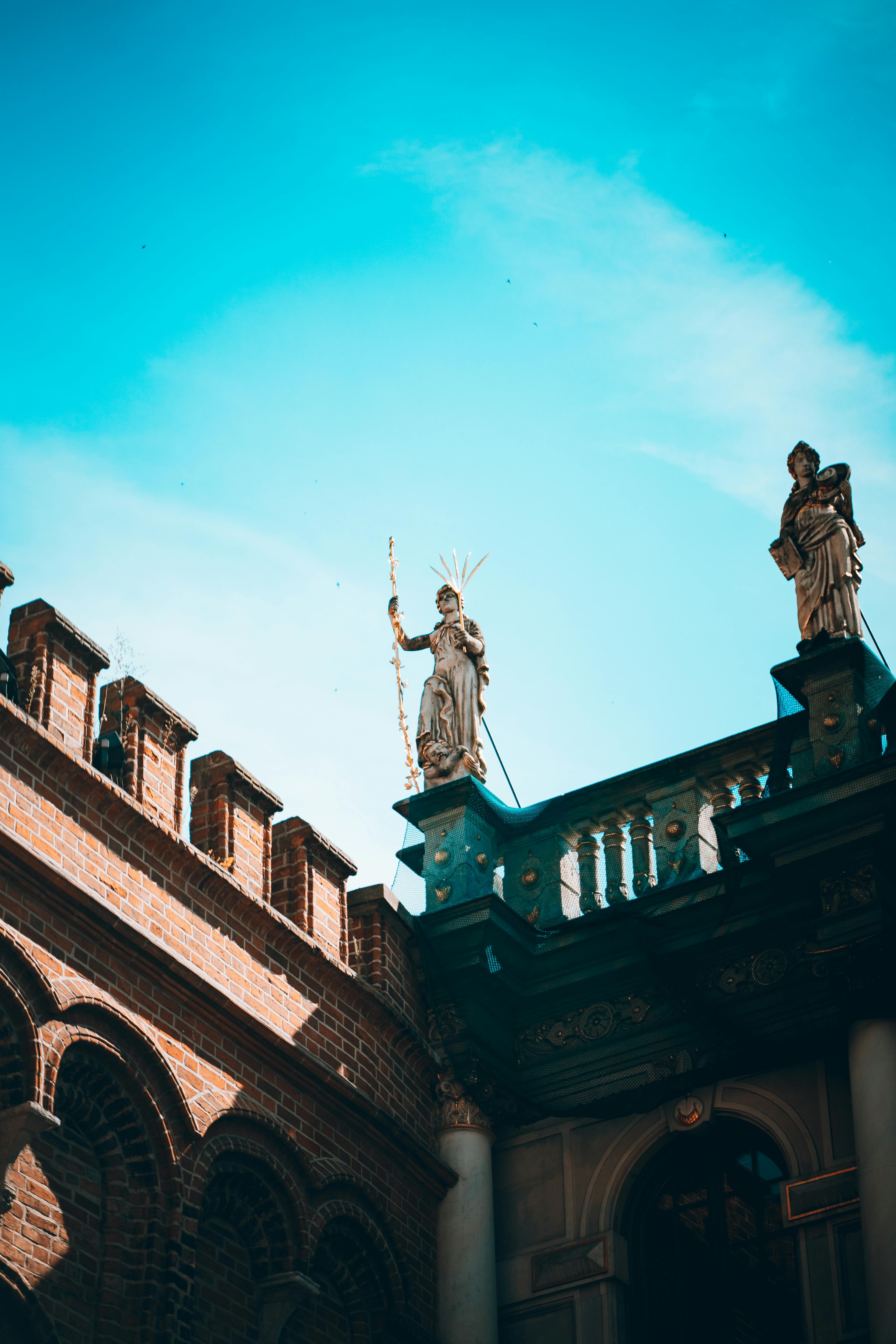 Statues on Pedestals on a Concrete and Brick Building · Free Stock Photo
