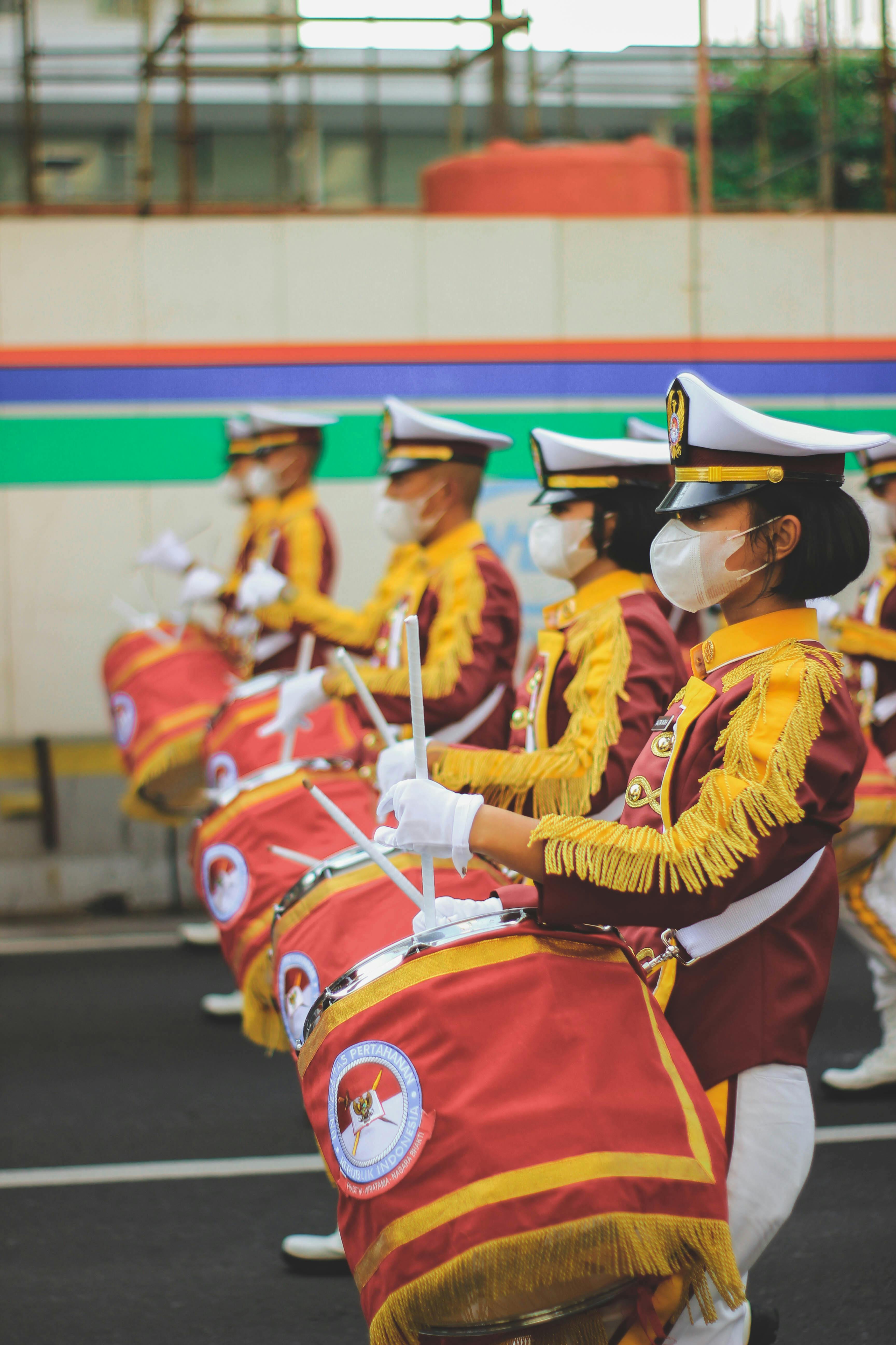 Women and Men in Masks and Uniforms Playing Drums on Parade · Free ...