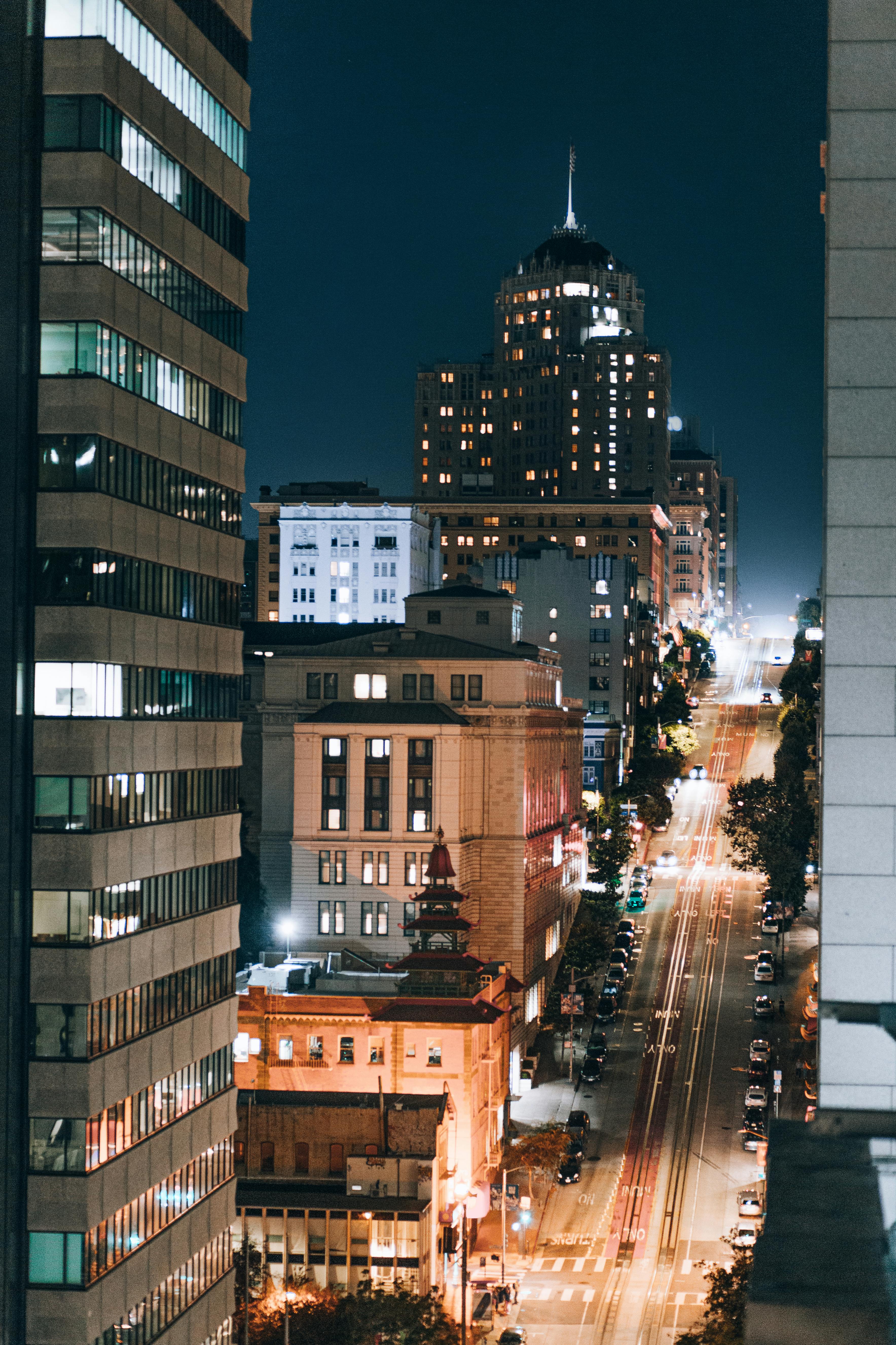 Cars on Road Between High Rise Buildings during Night Time · Free Stock ...