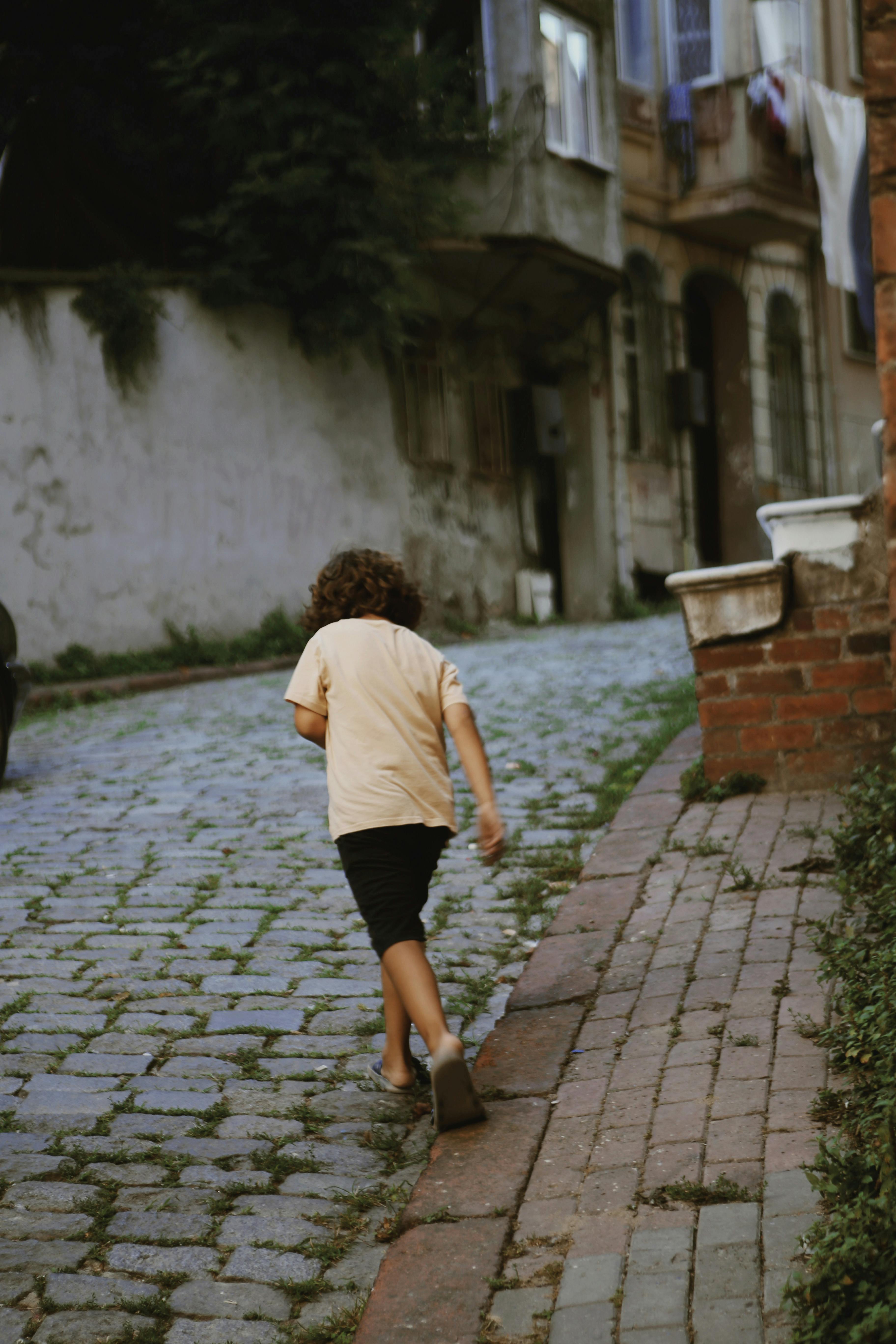 Boy Walking on Sidewalk · Free Stock Photo