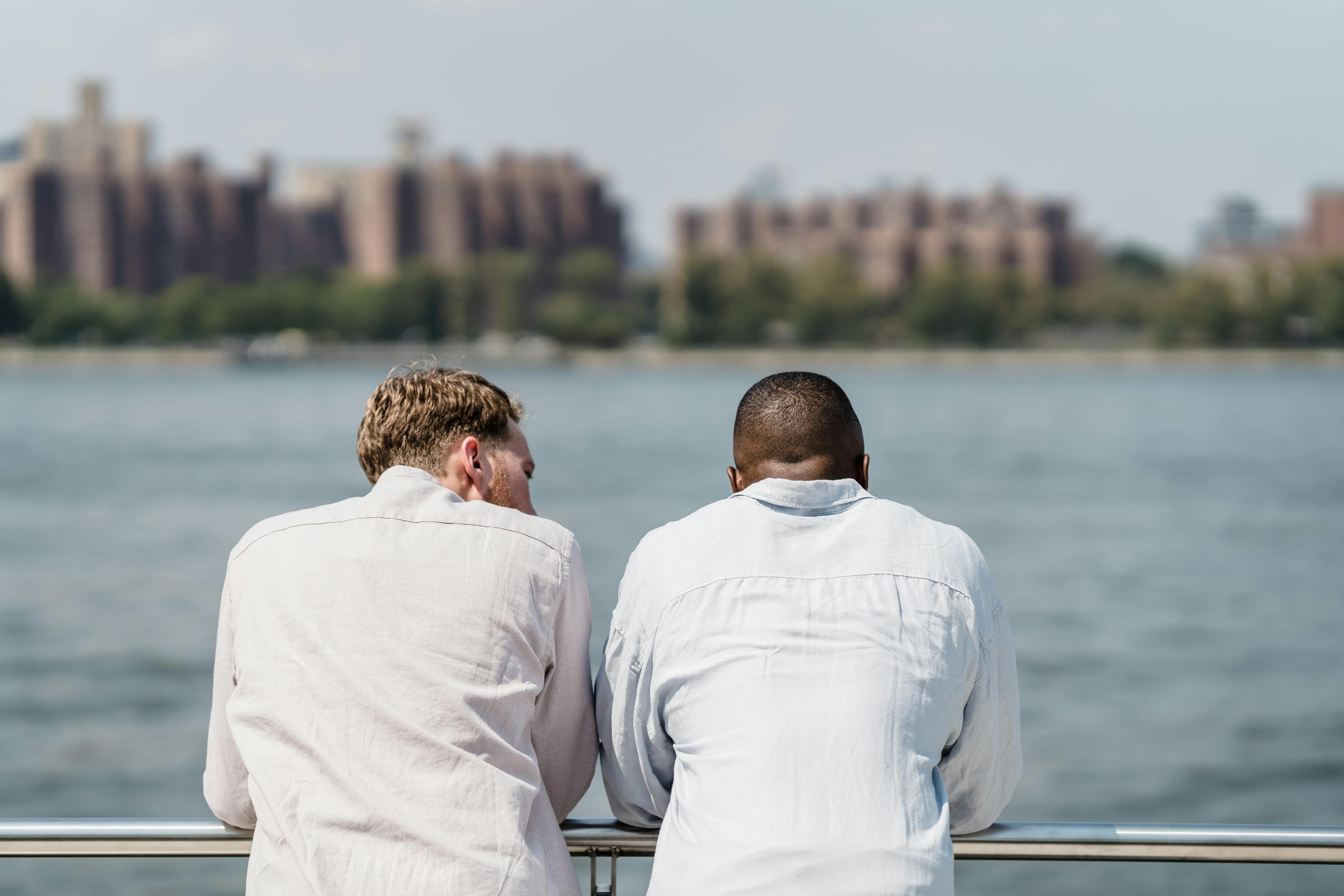 Two Men Sitting by the Water · Free Stock Photo
