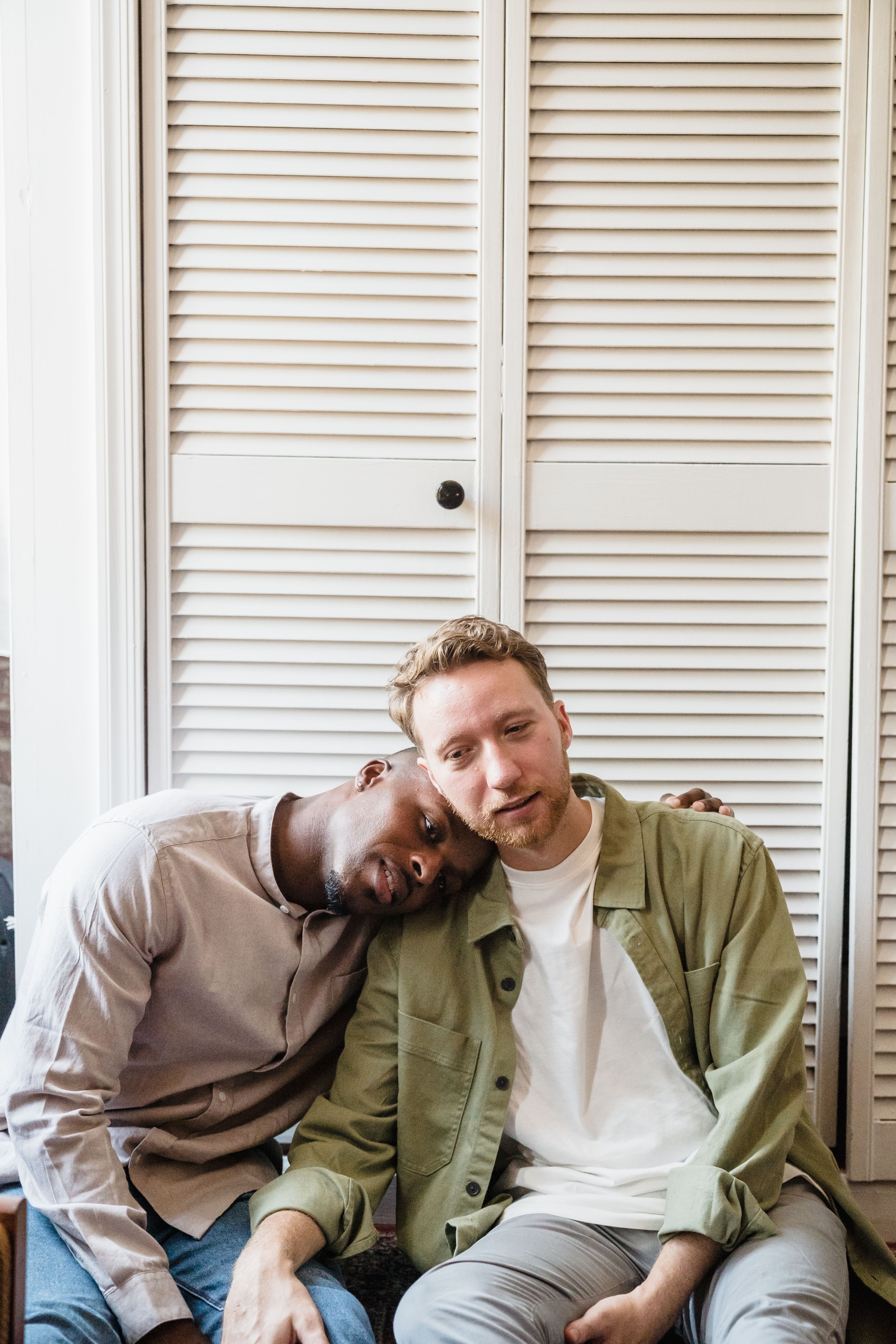 Men Sitting and Hugging by Wardrobe · Free Stock Photo