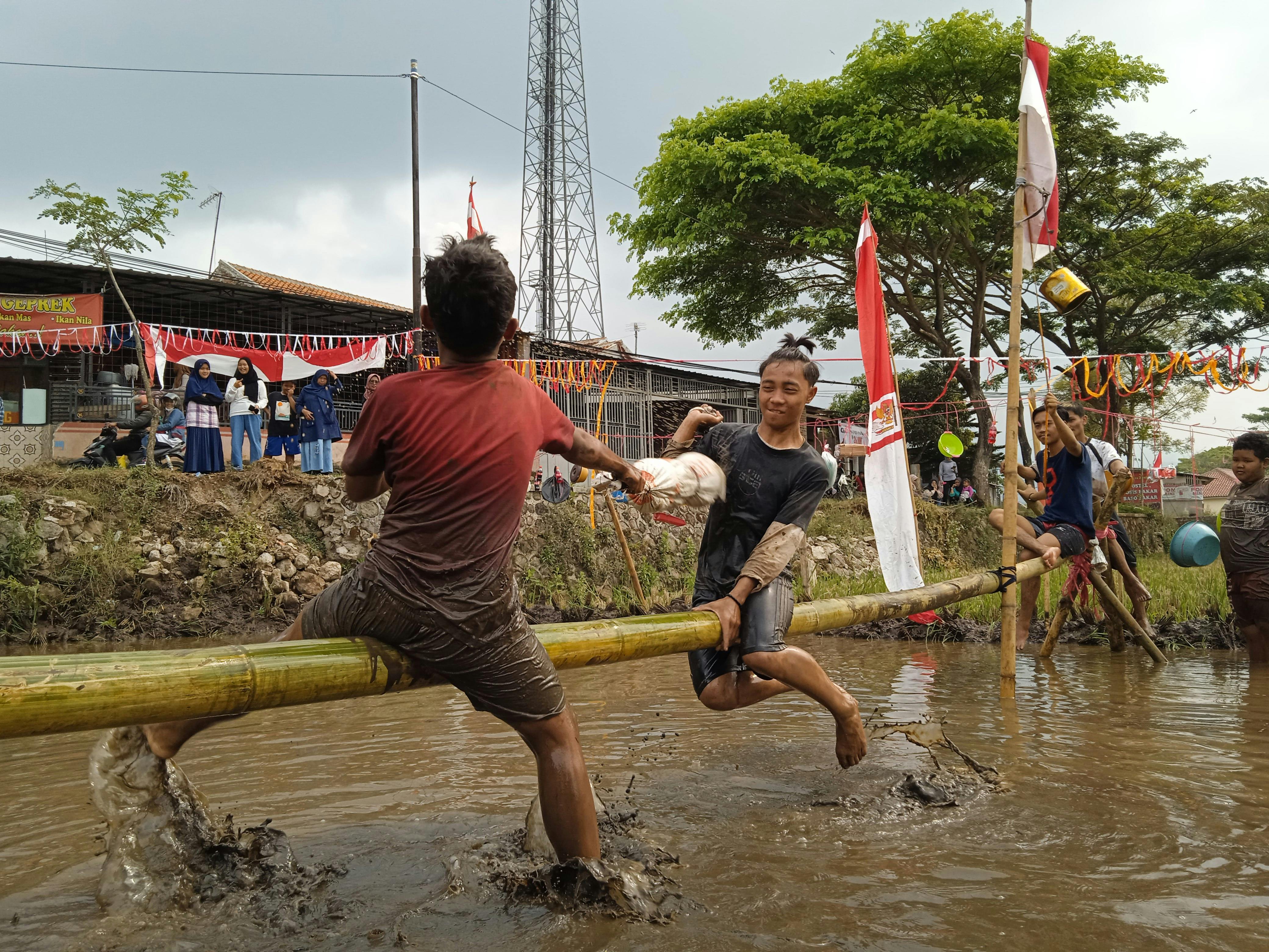 Children Sitting on a Bamboo Pole Playing Over a Body of Water · Free ...