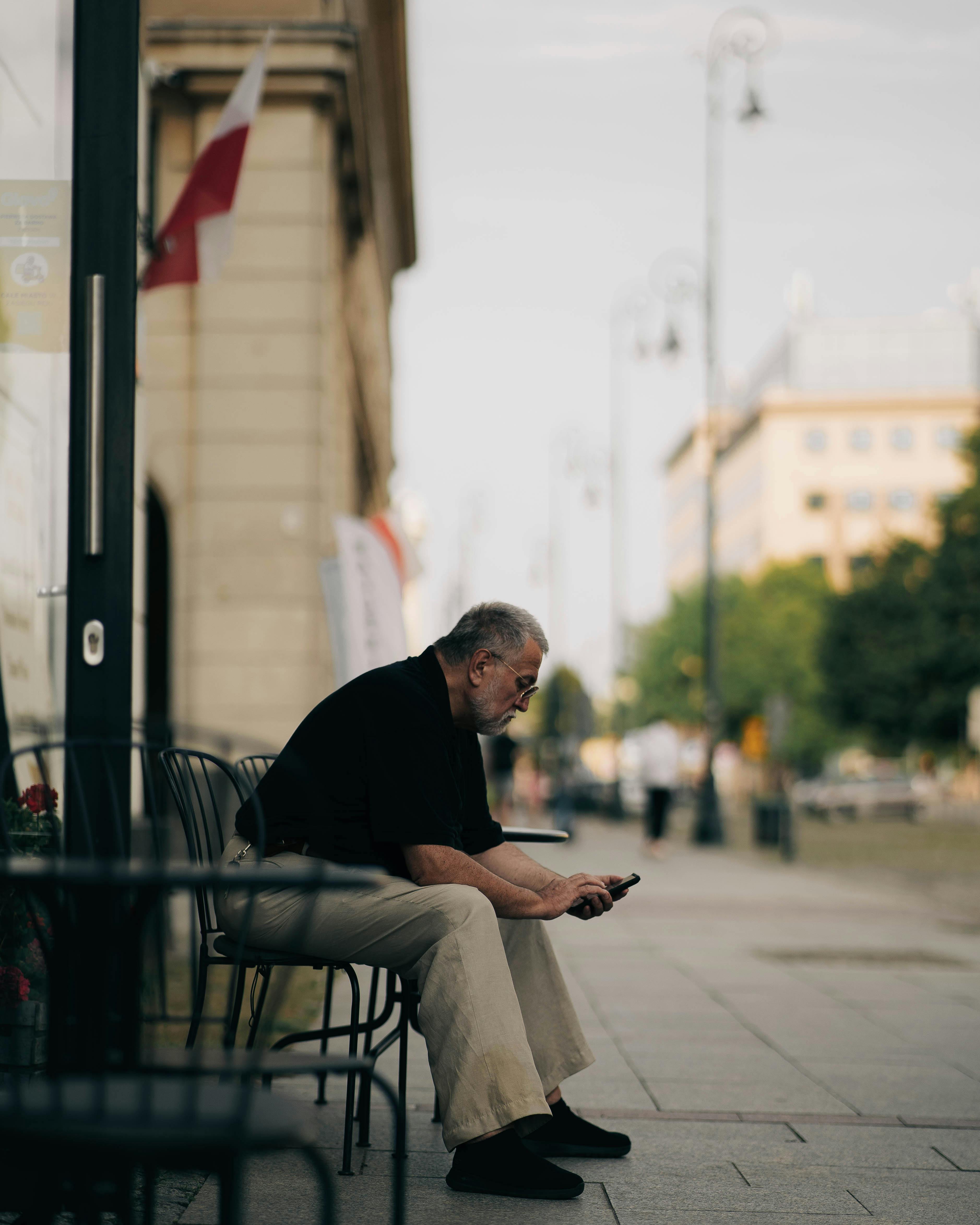 A Man Sitting While using Smartphone · Free Stock Photo