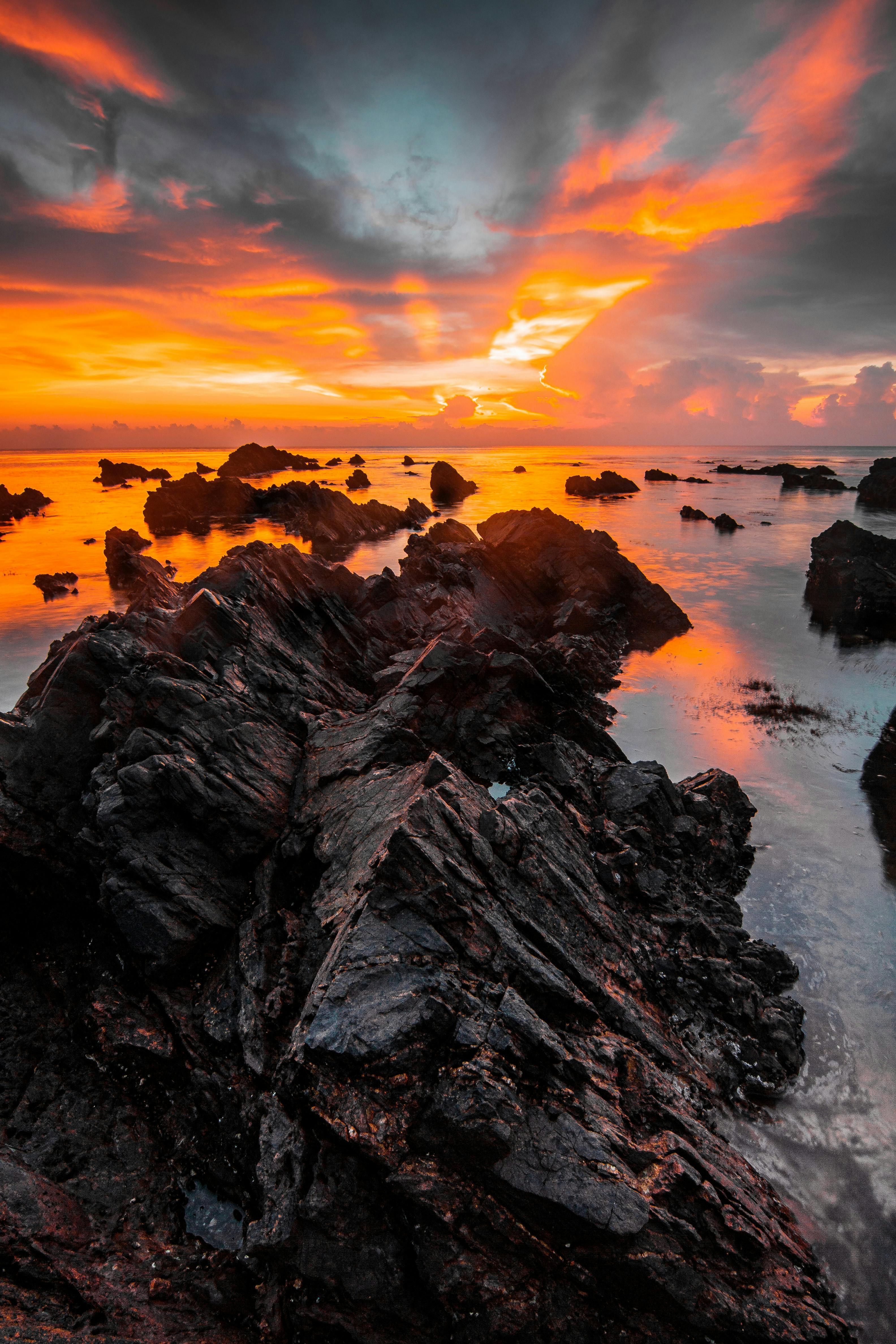 Dramatic Sunset above Rocks in Sea · Free Stock Photo