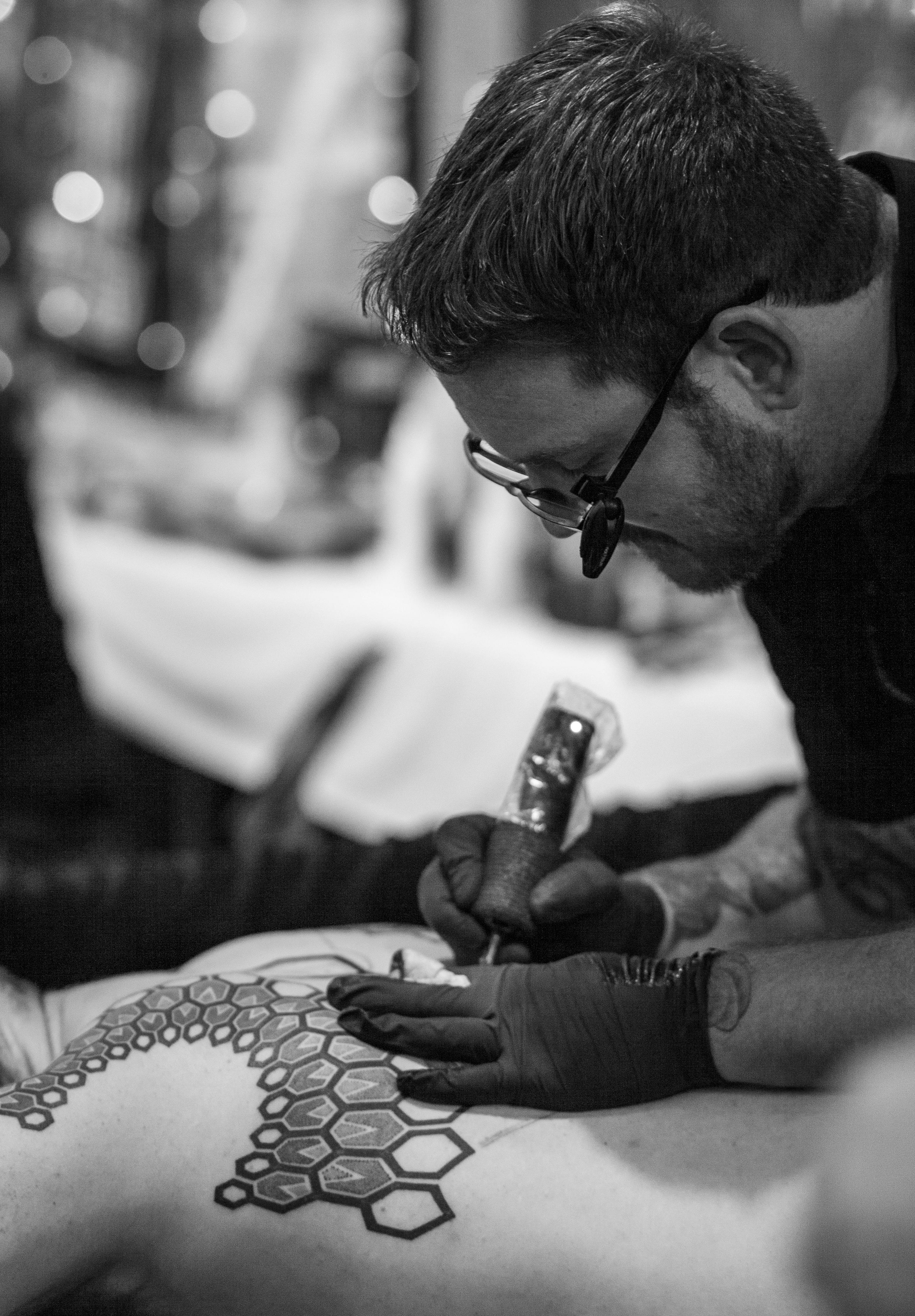 Monochrome Photo of Tattoo Artist tattooing a Client · Free Stock Photo