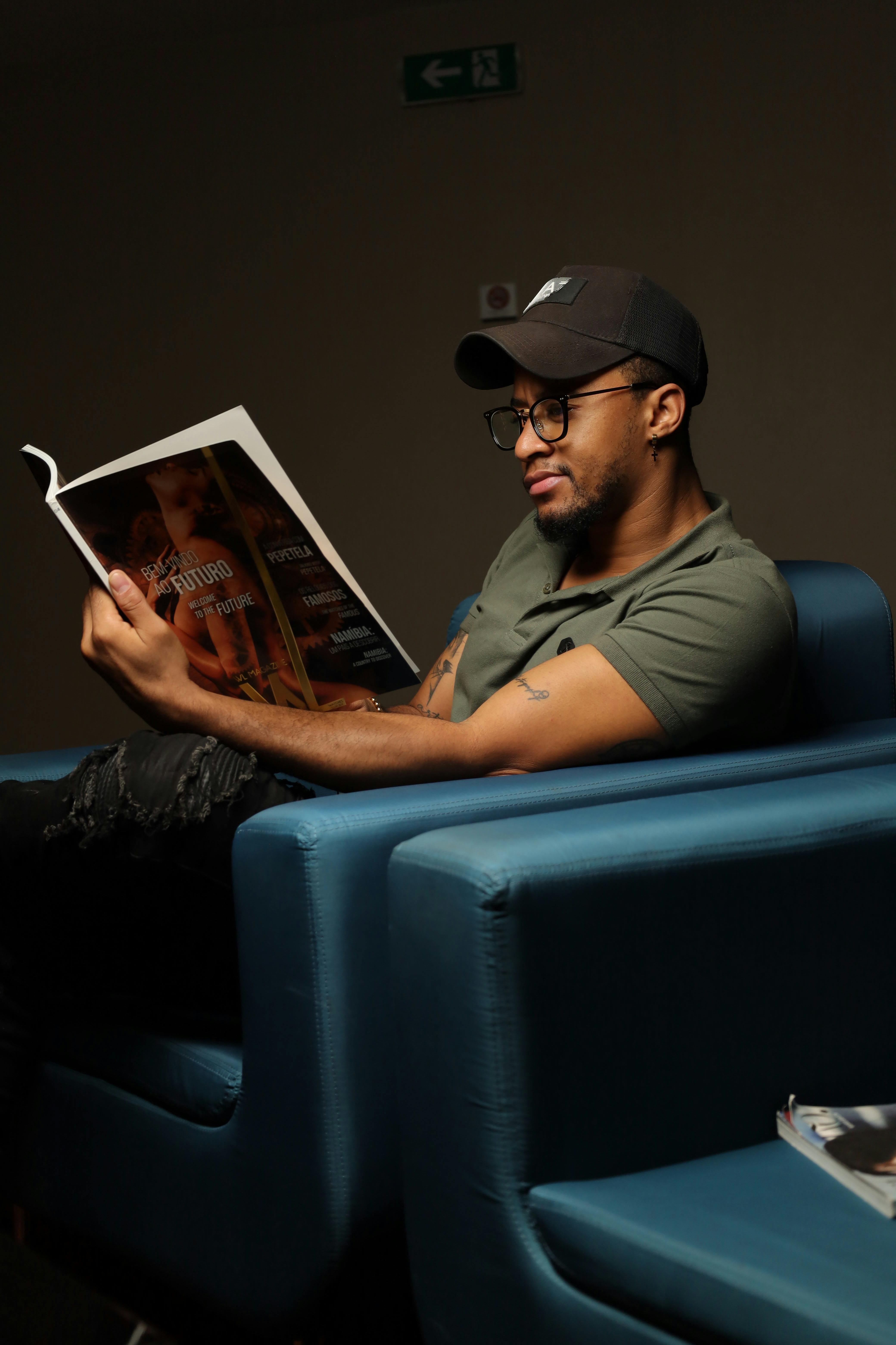 Photo of a Man Reading a Magazine on a Bed · Free Stock Photo