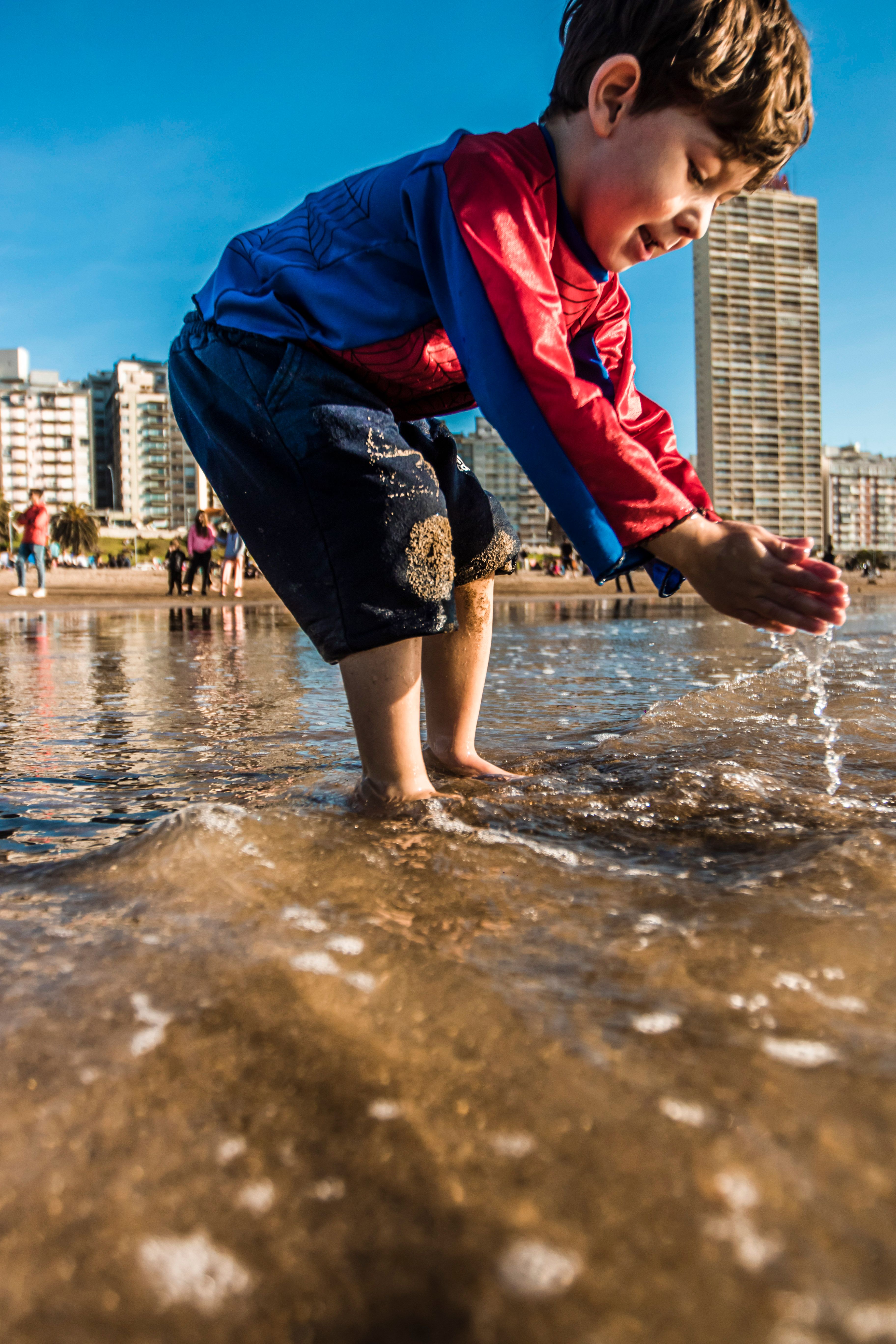 Photo of Boy Swinging Over Body of Water · Free Stock Photo
