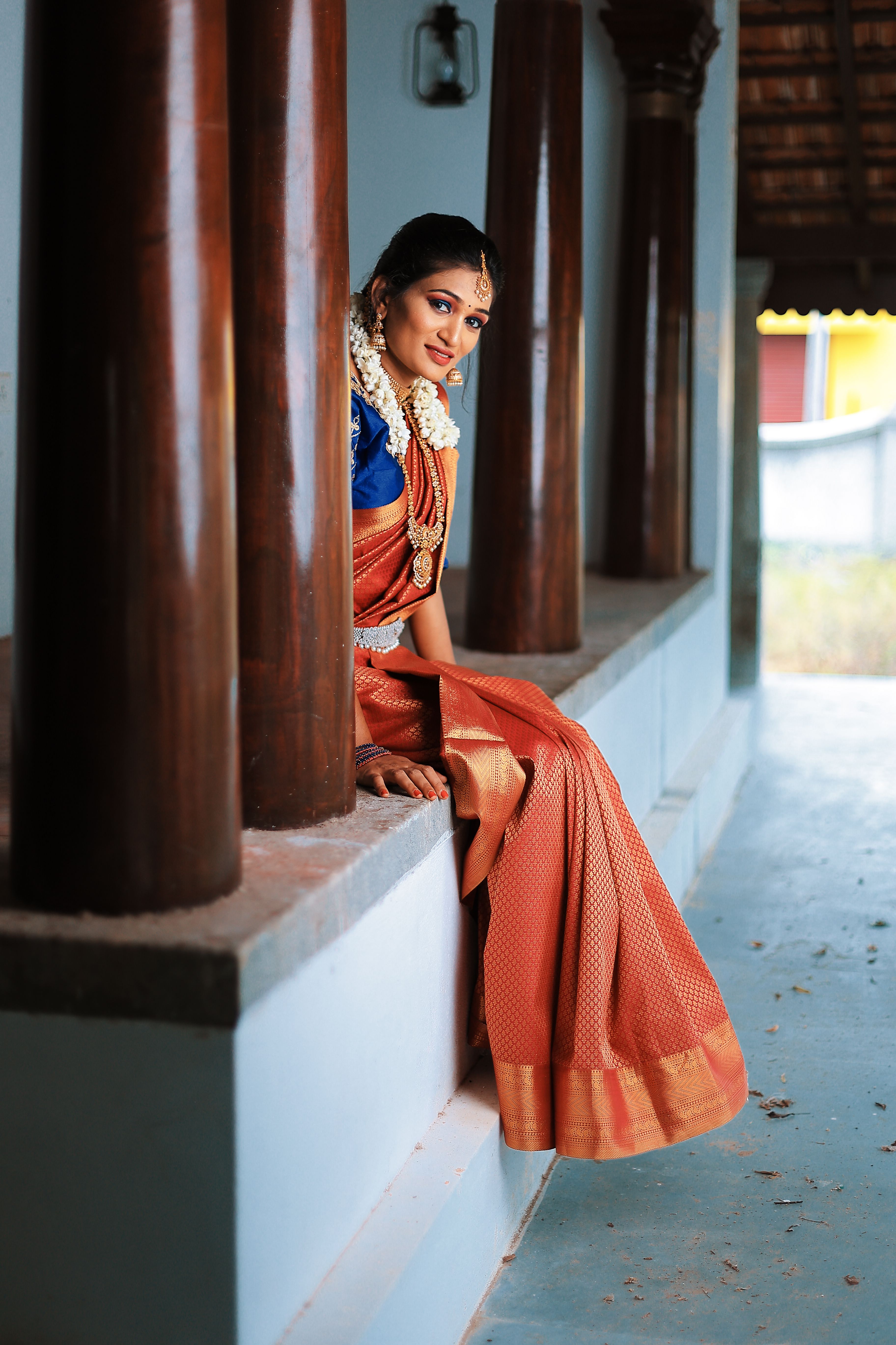 Woman Sitting by Column on Wall · Free Stock Photo