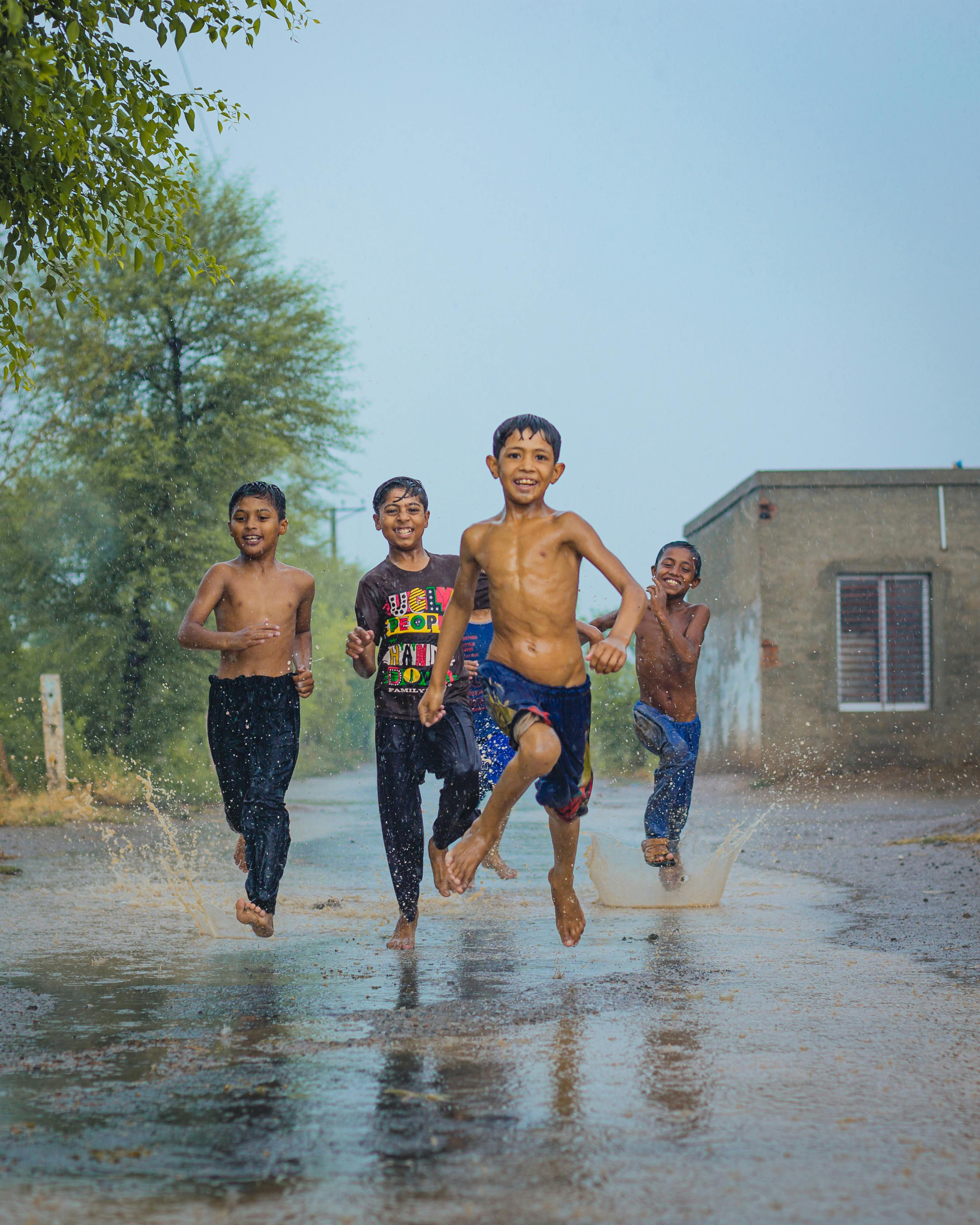 Boy in Blue Jacket Hopping on Water Puddle · Free Stock Photo