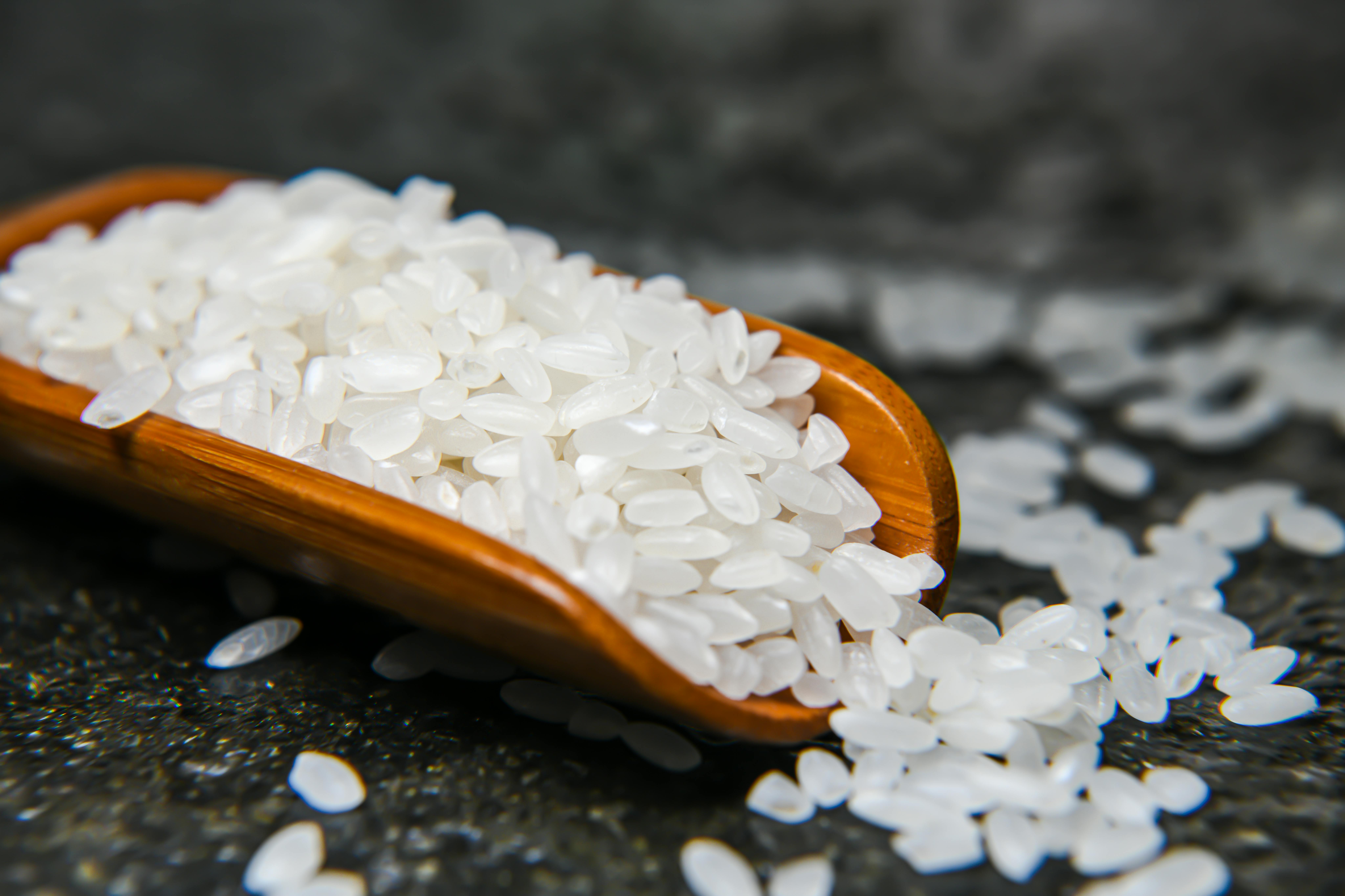 Close-Up Photo of Rice Grains on Measuring Wooden Scoop · Free Stock Photo