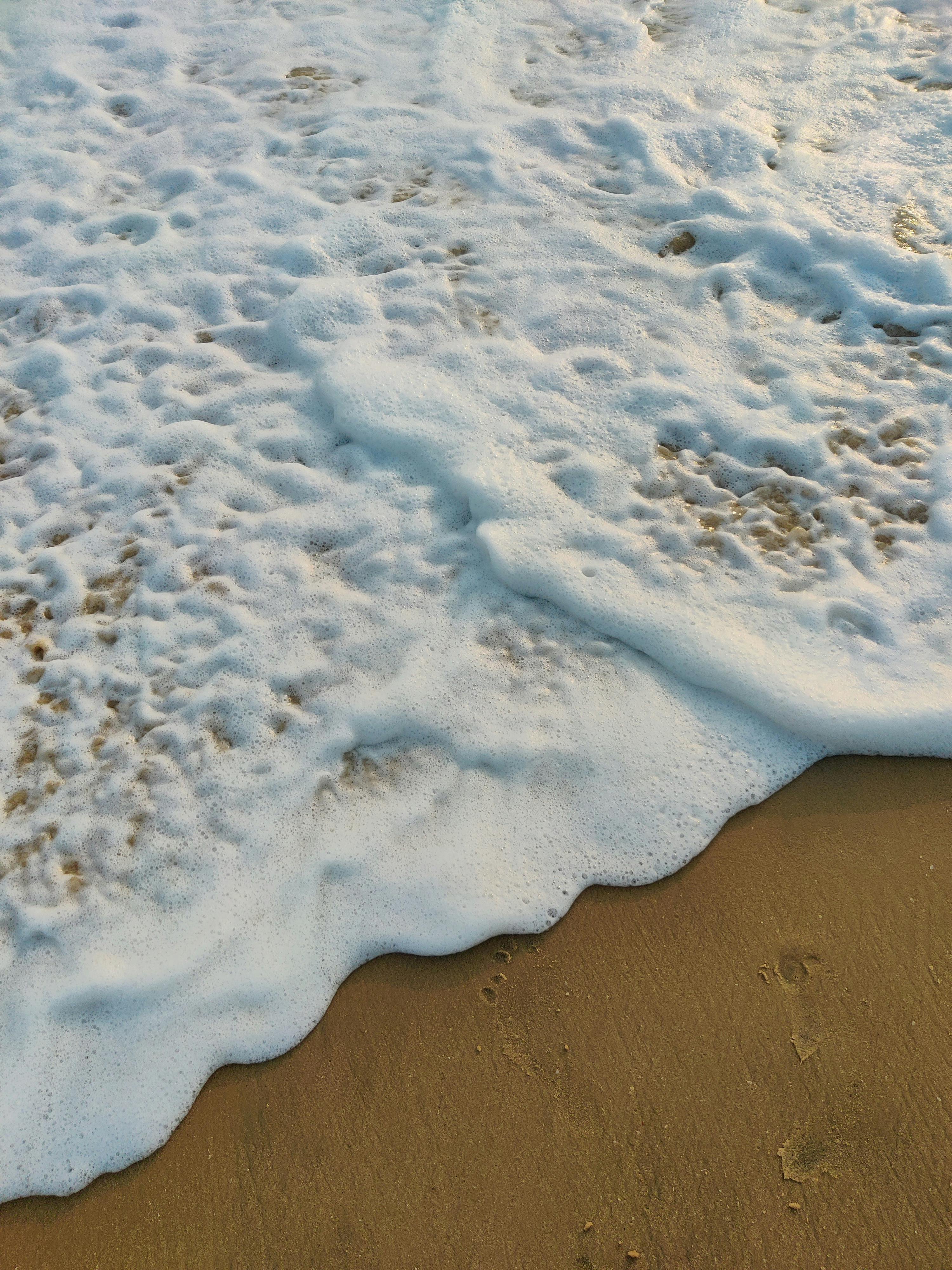 Close-up of a Foamy Wave Washing Up the Beach · Free Stock Photo