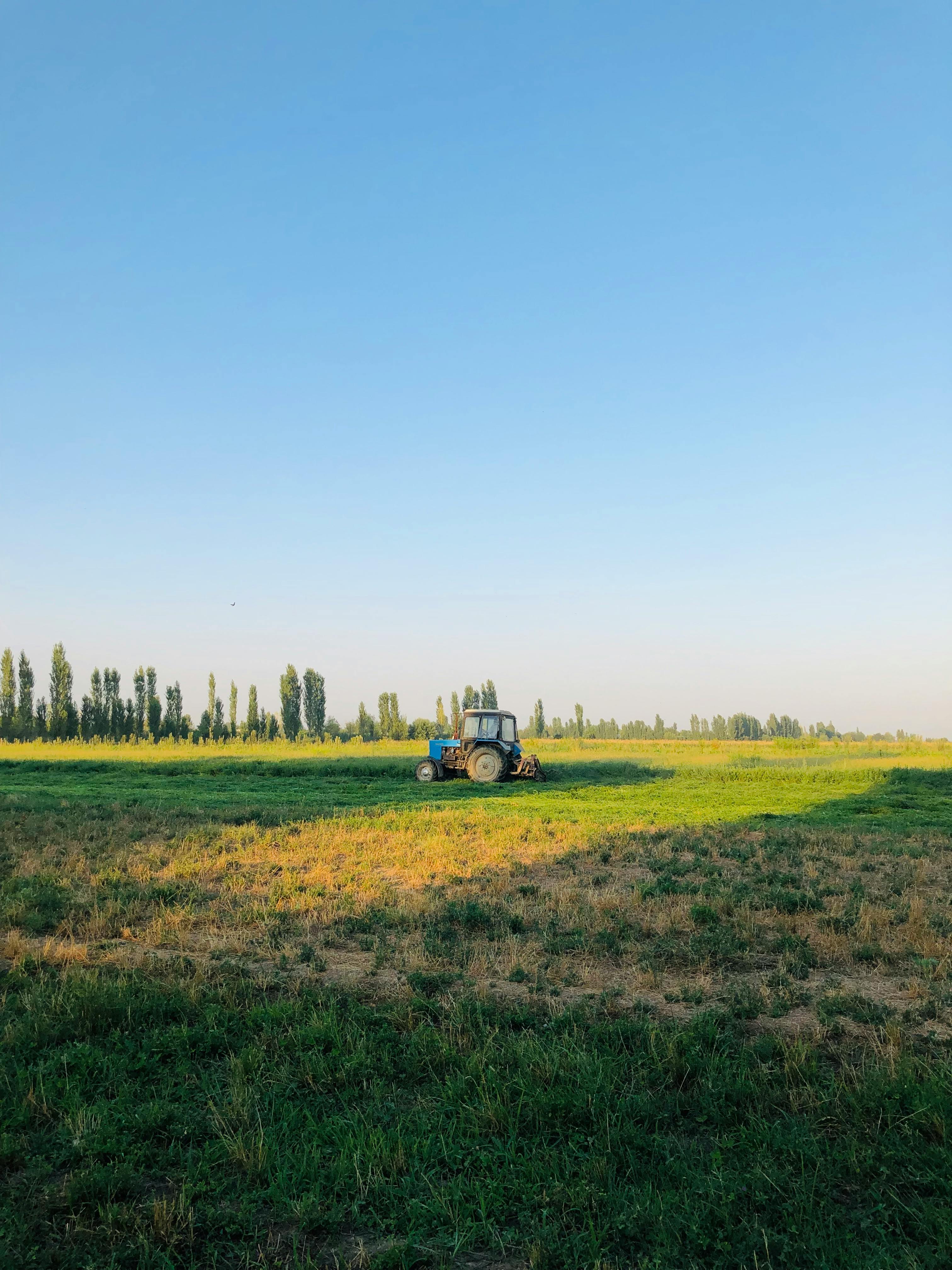 Red Tractor Standing on Rural Road · Free Stock Photo