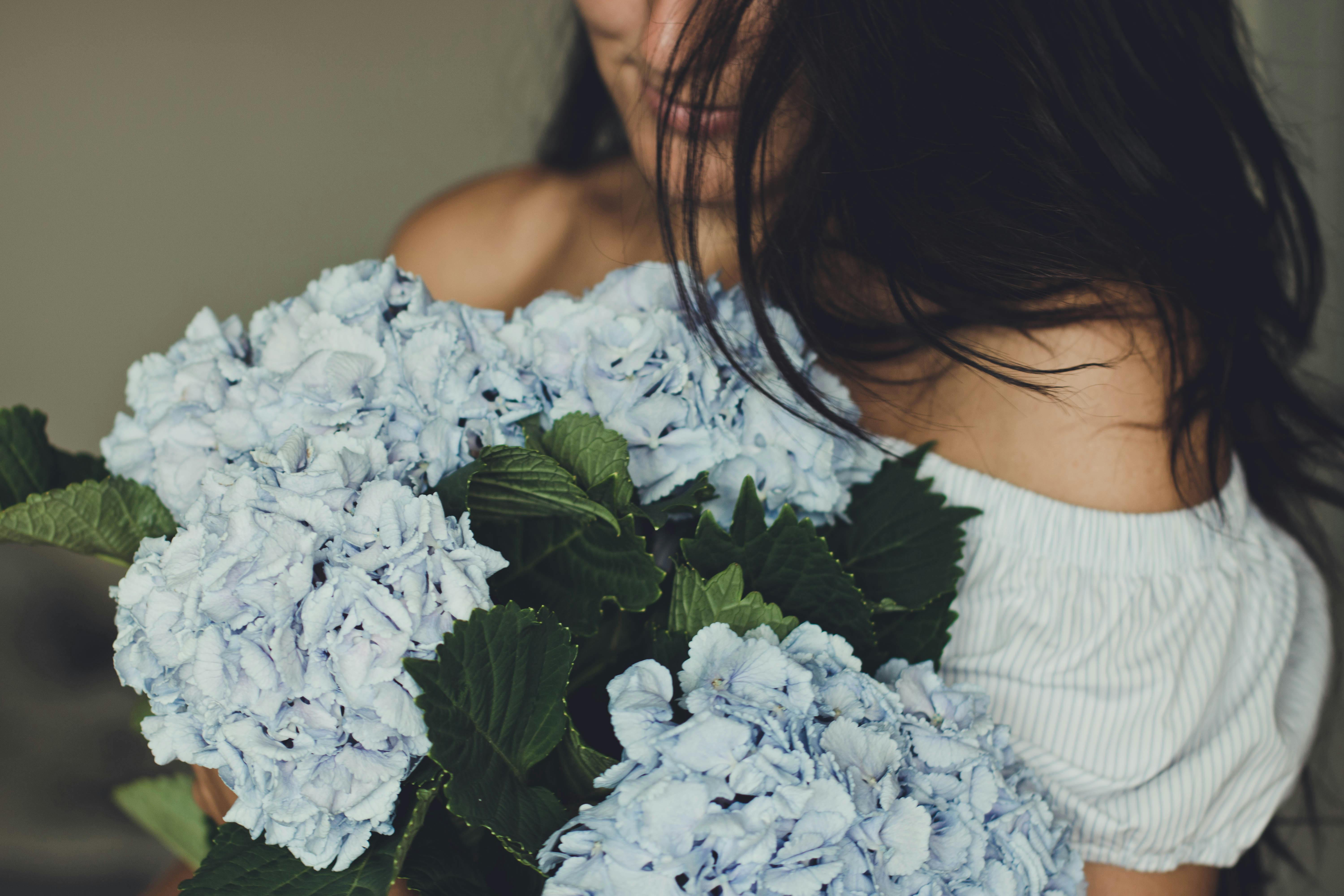 Woman Holding Blue Flowers · Free Stock Photo