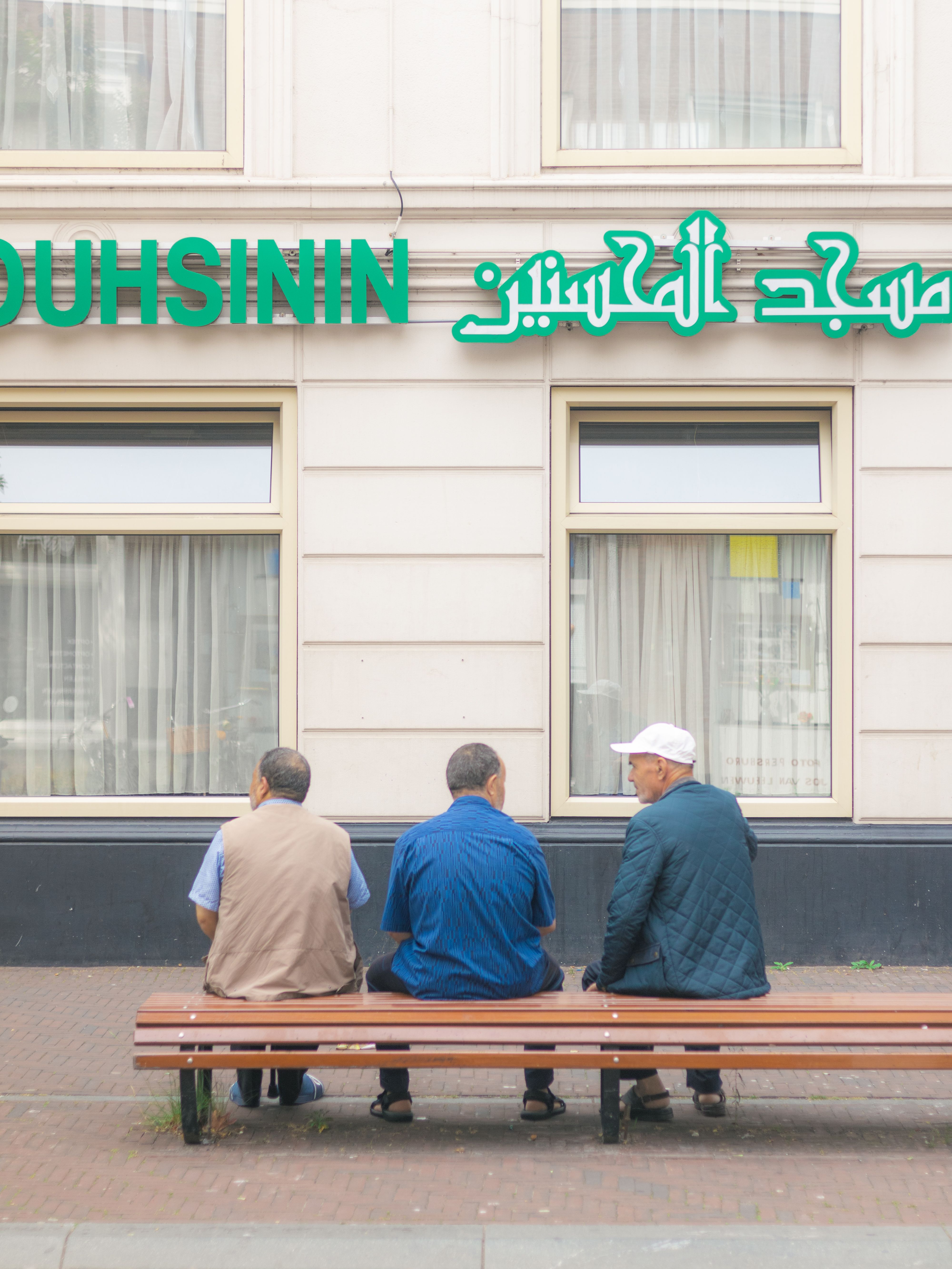 A Three Men Sitting on the Bench Together · Free Stock Photo