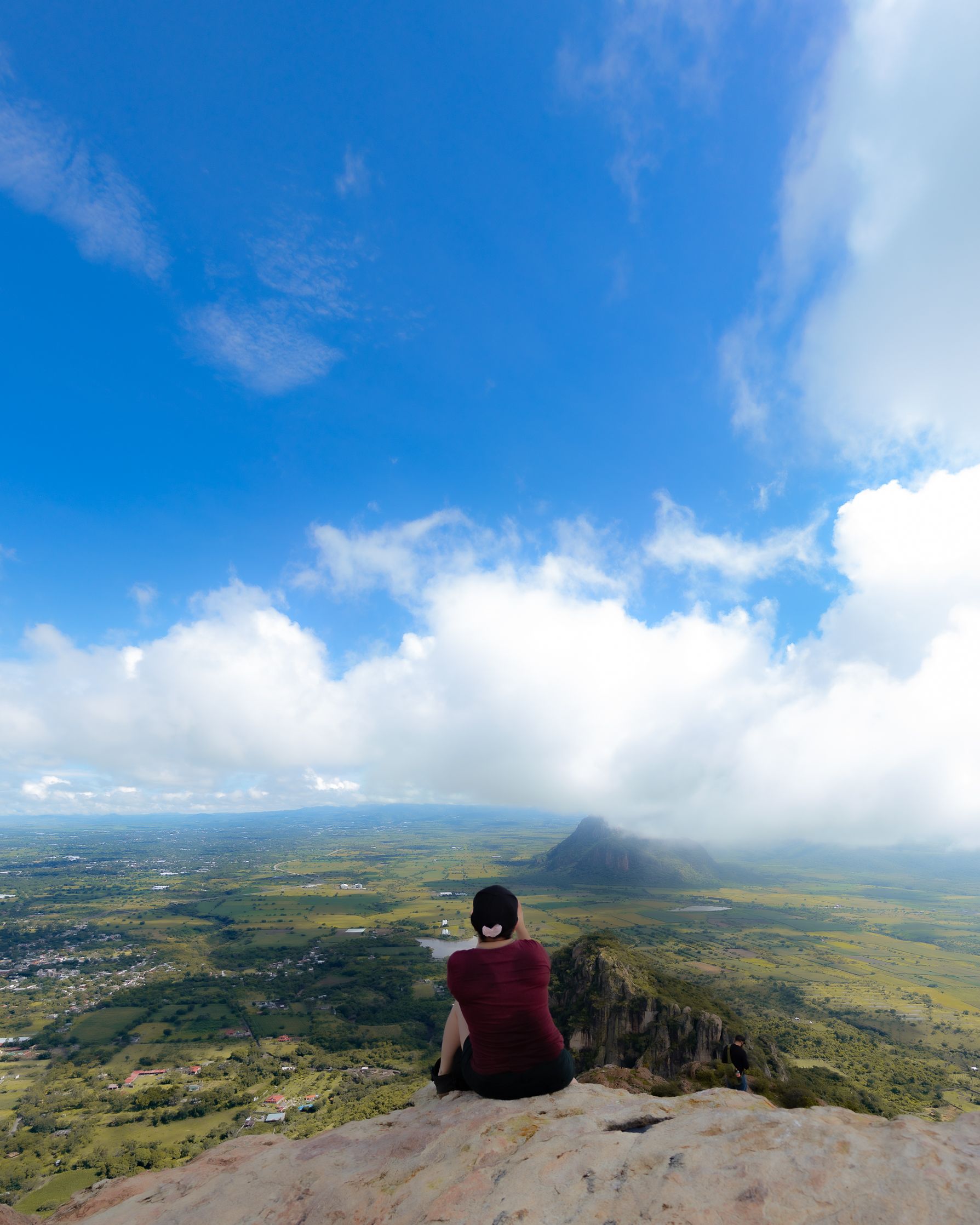 Back View of a Person Sitting on Mountain Top under the Cloudy Blue Sky ...