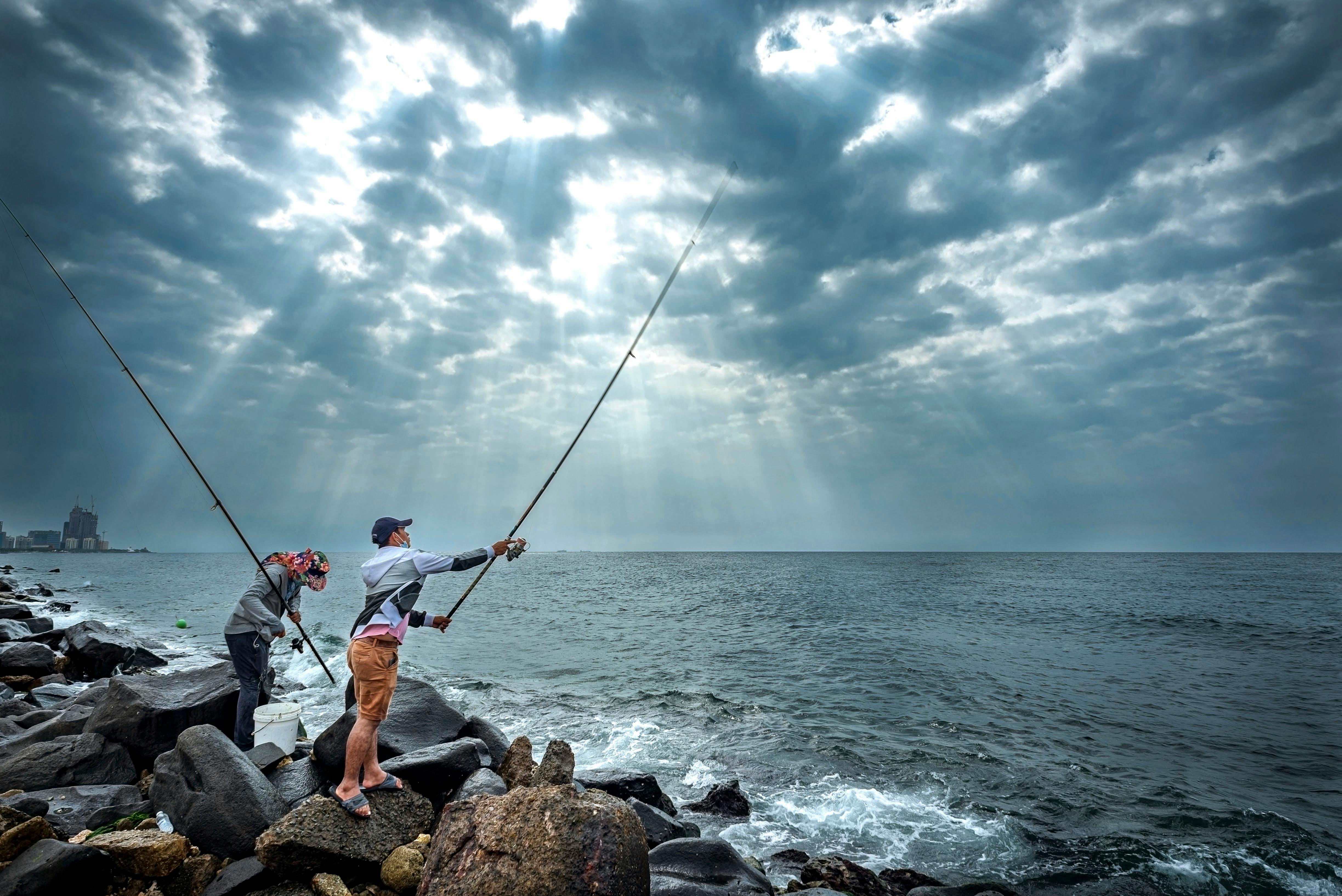 Silhouettes of Fishermen at Sea at Dusk · Free Stock Photo