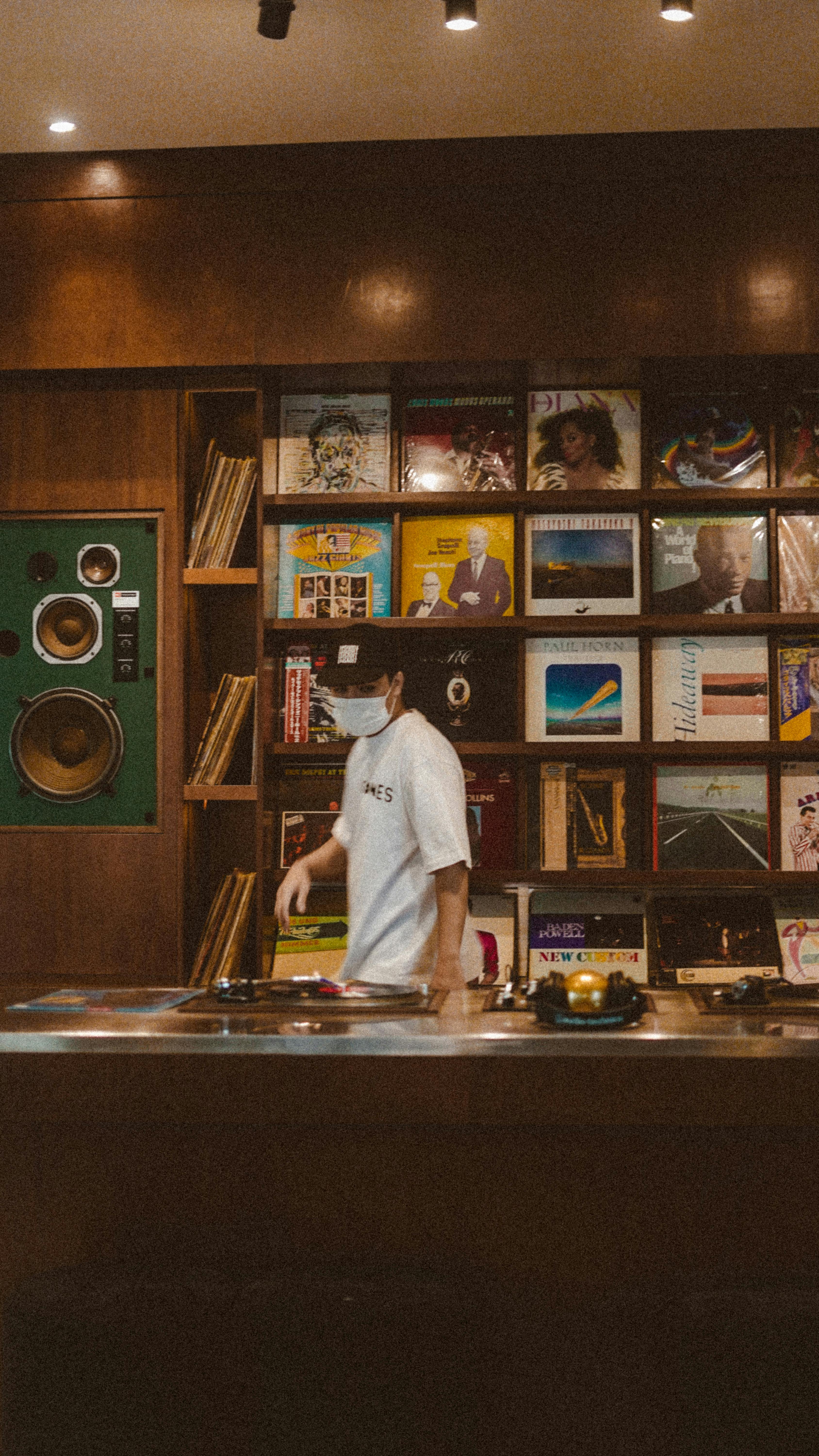 A Person in White Shirt Wearing face Mask Standing Behind a Counter ...