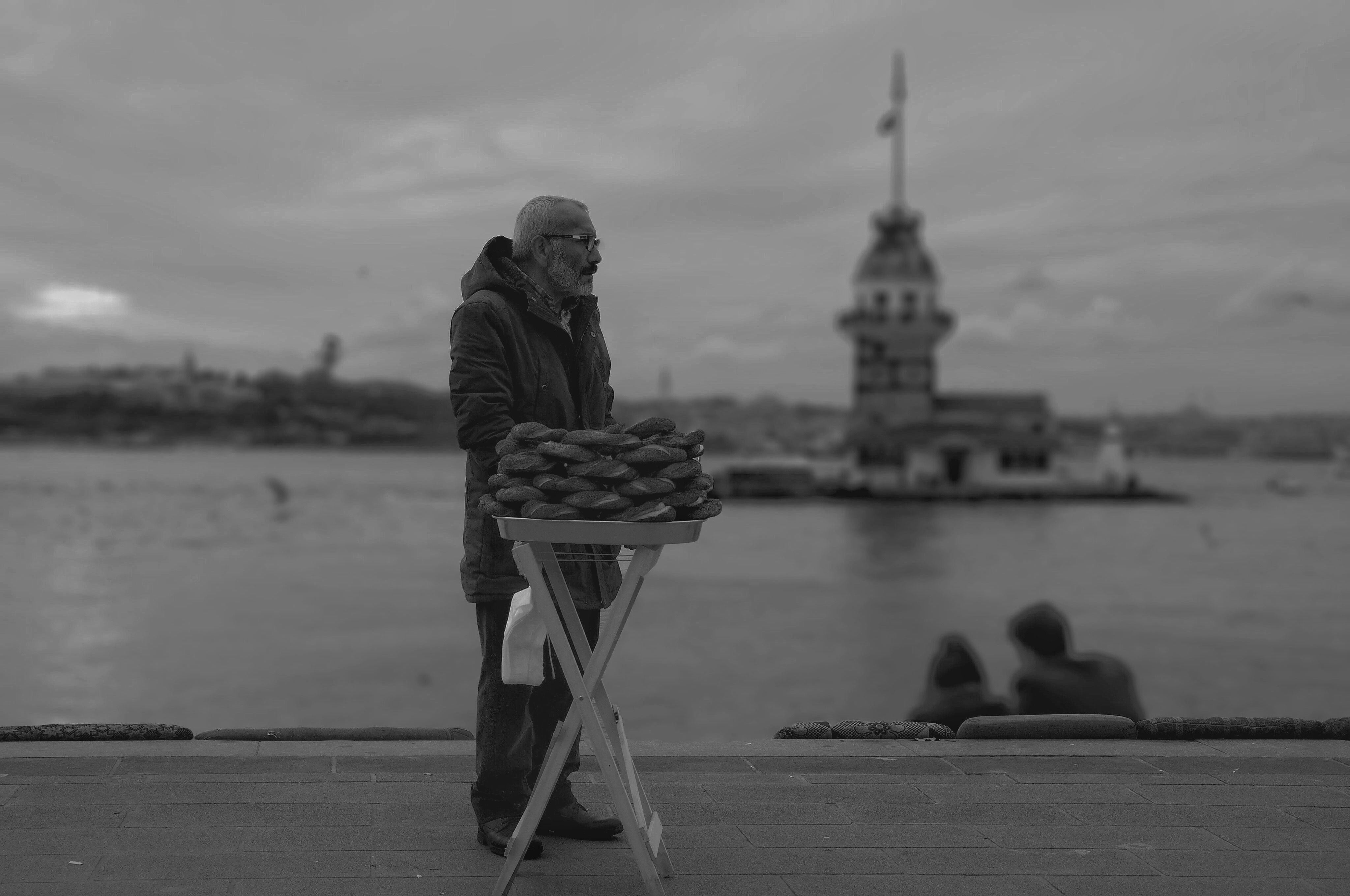 An Elderly Man Standing Beside a Wooden Table with Breads · Free Stock ...