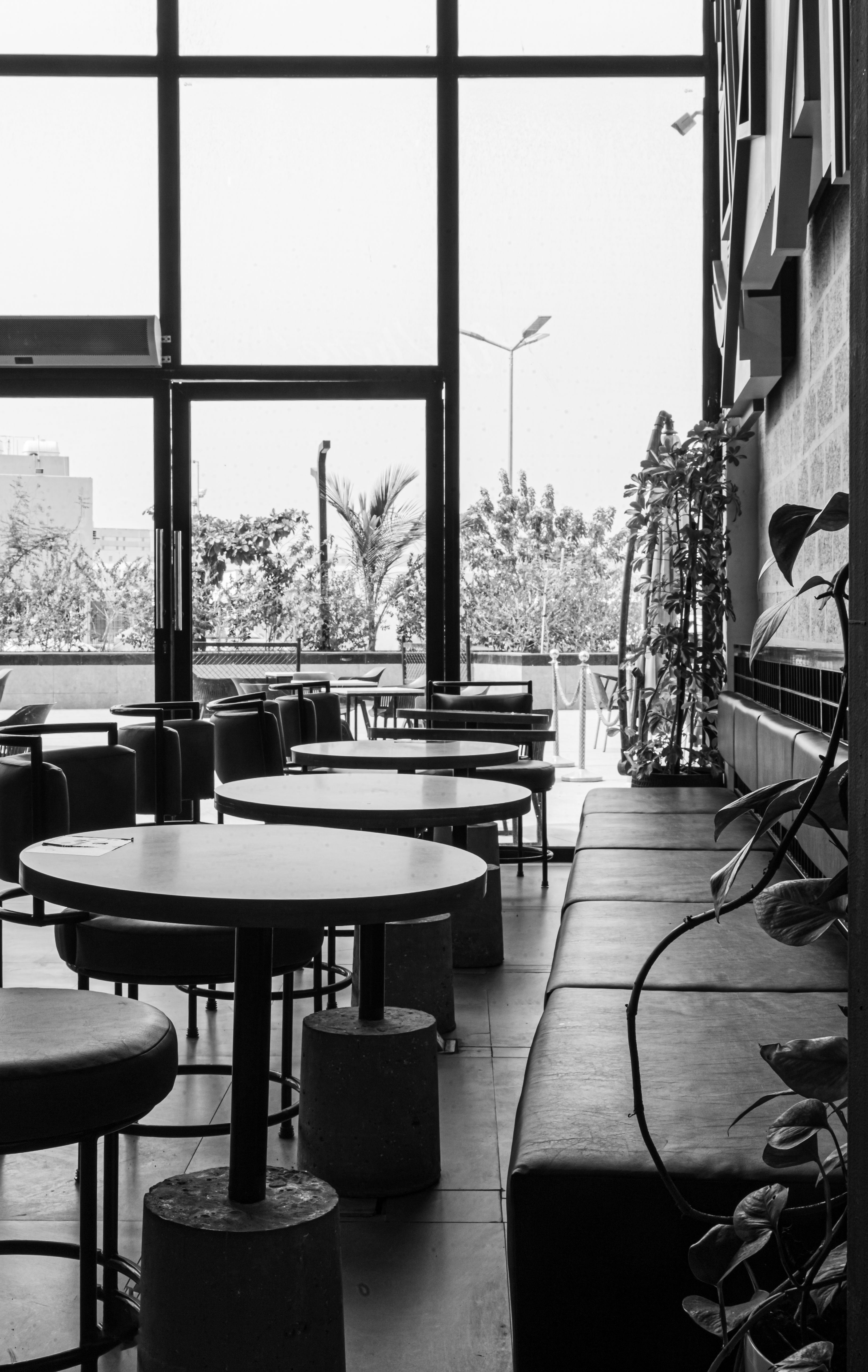 A Grayscale Photo of Tables and Chairs Inside the Café · Free Stock Photo