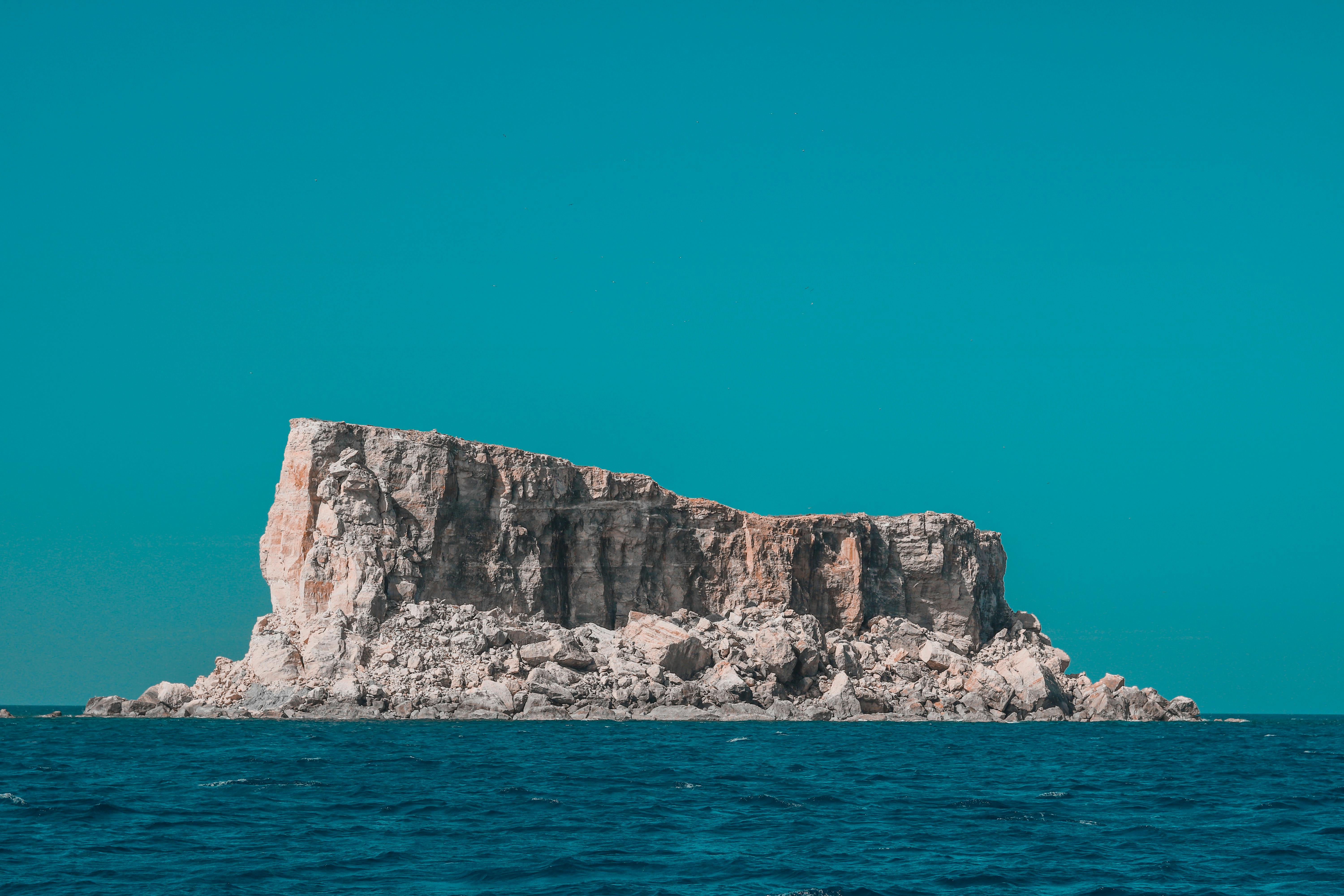 Brown Rock Formation on the Middle of the Sea Under Blue Sky · Free ...