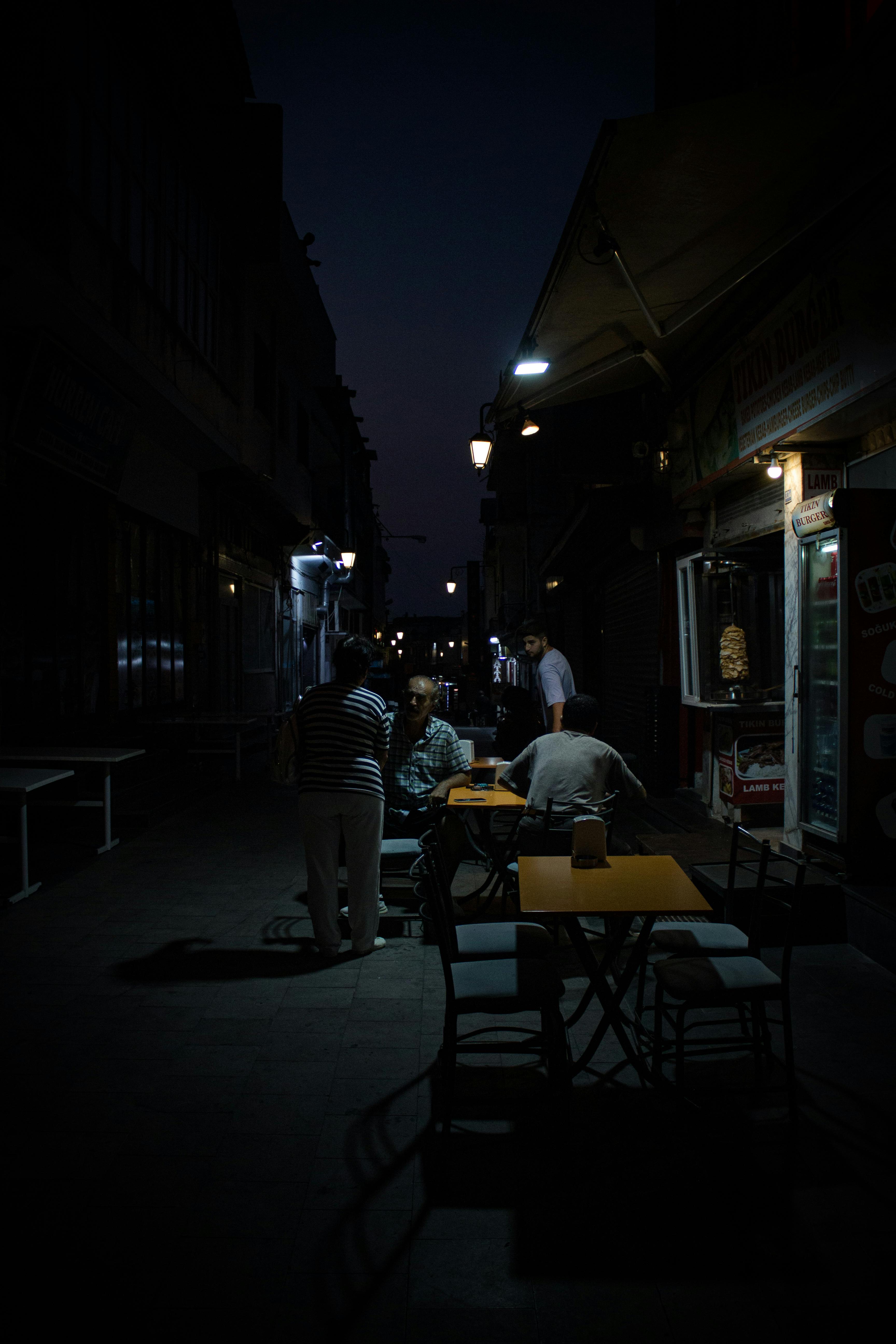 People Sitting on Chairs in front of a Store in an Alleyway · Free ...