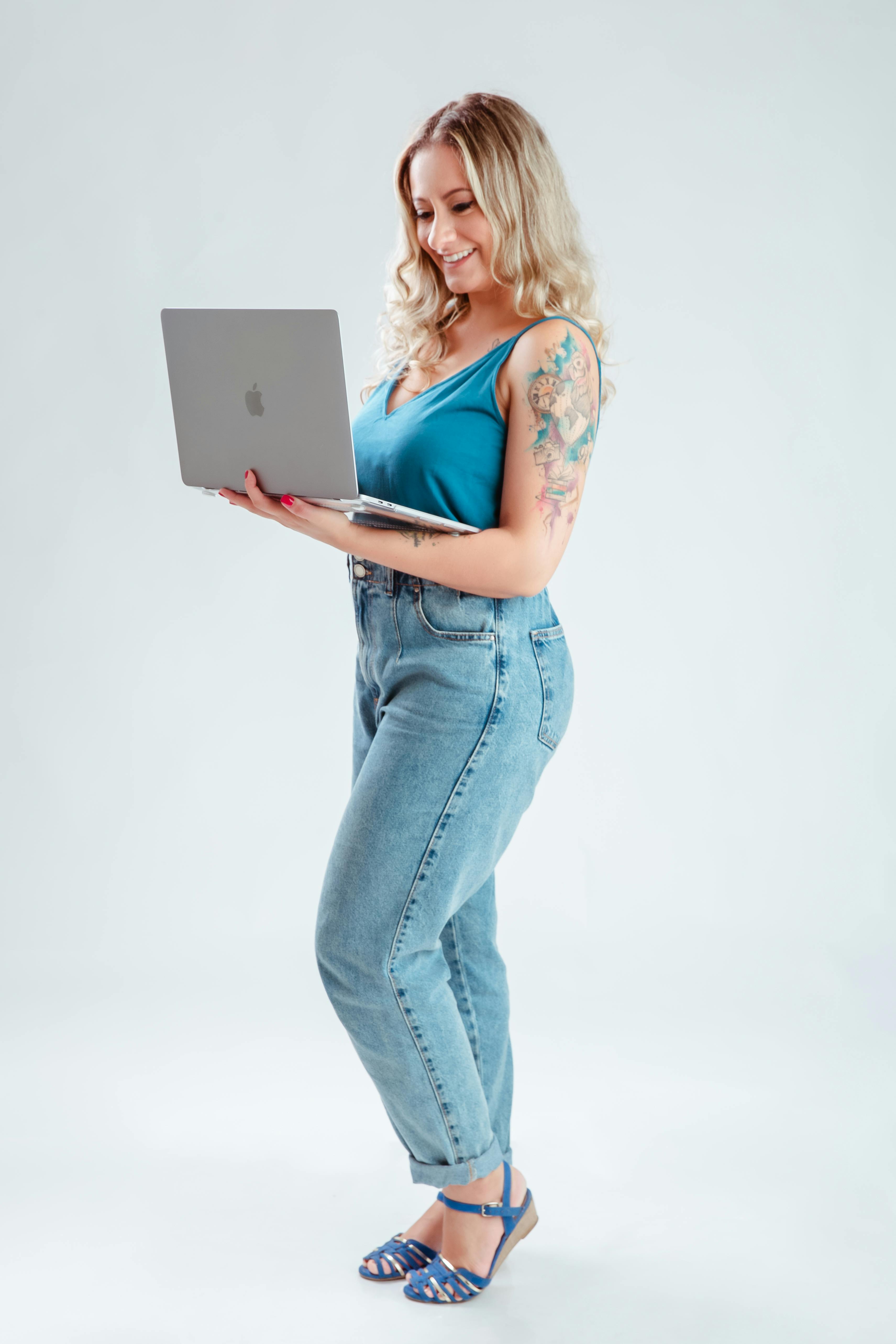 A Woman Standing While using Laptop · Free Stock Photo