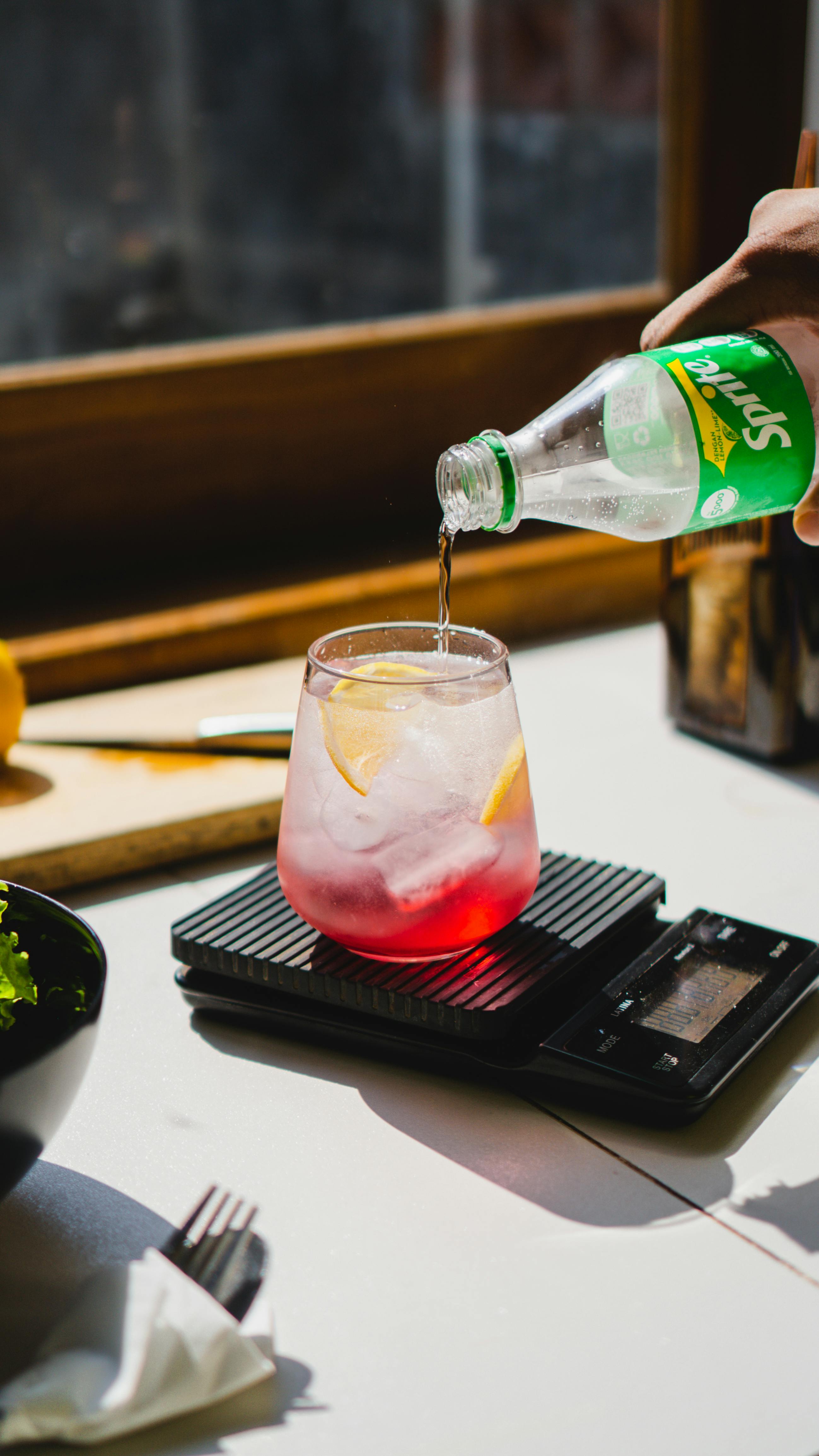 Photo of Person Pouring Sprite in Glass · Free Stock Photo