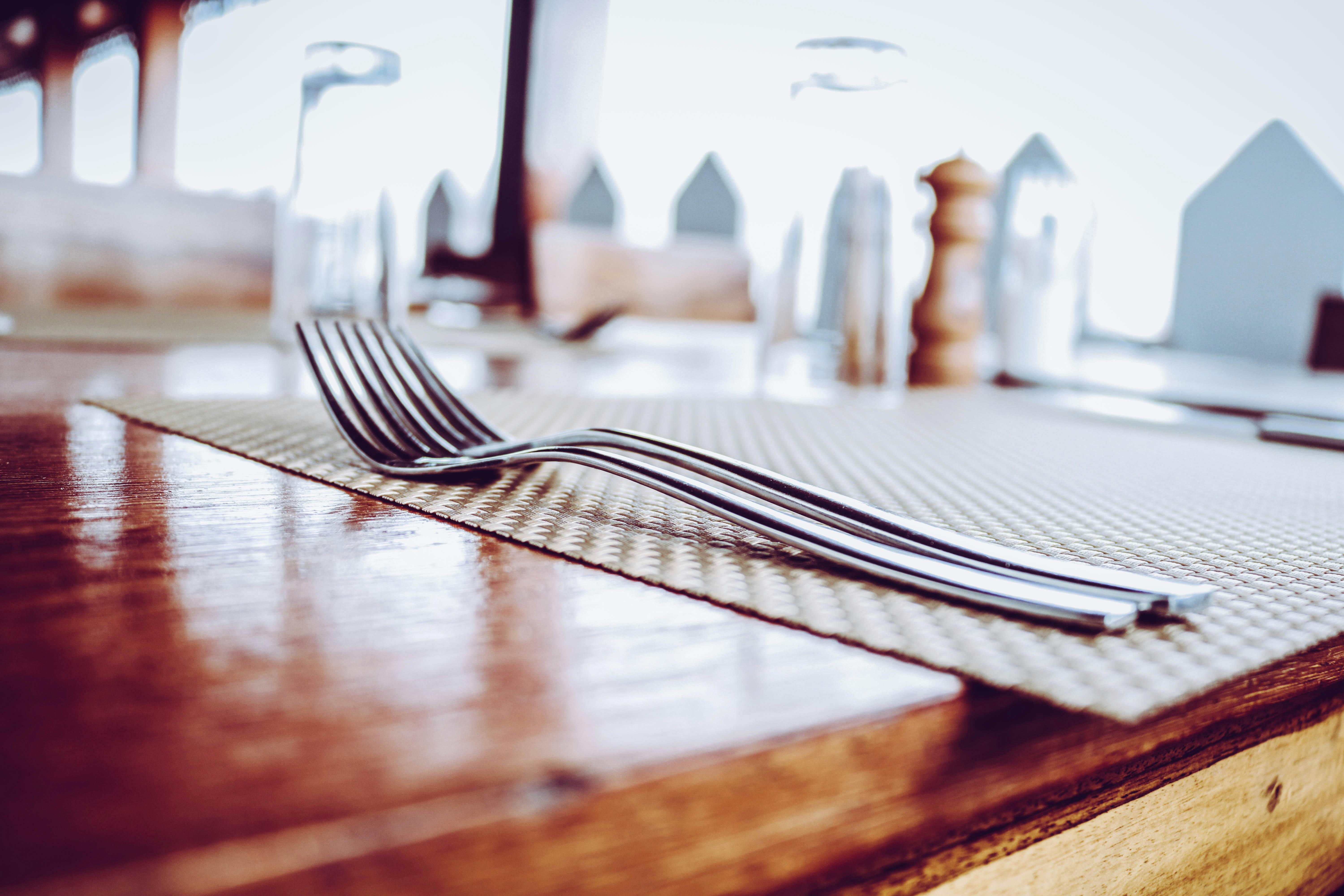 Two Stainless Steel Forks on Top of Place Mat · Free Stock Photo