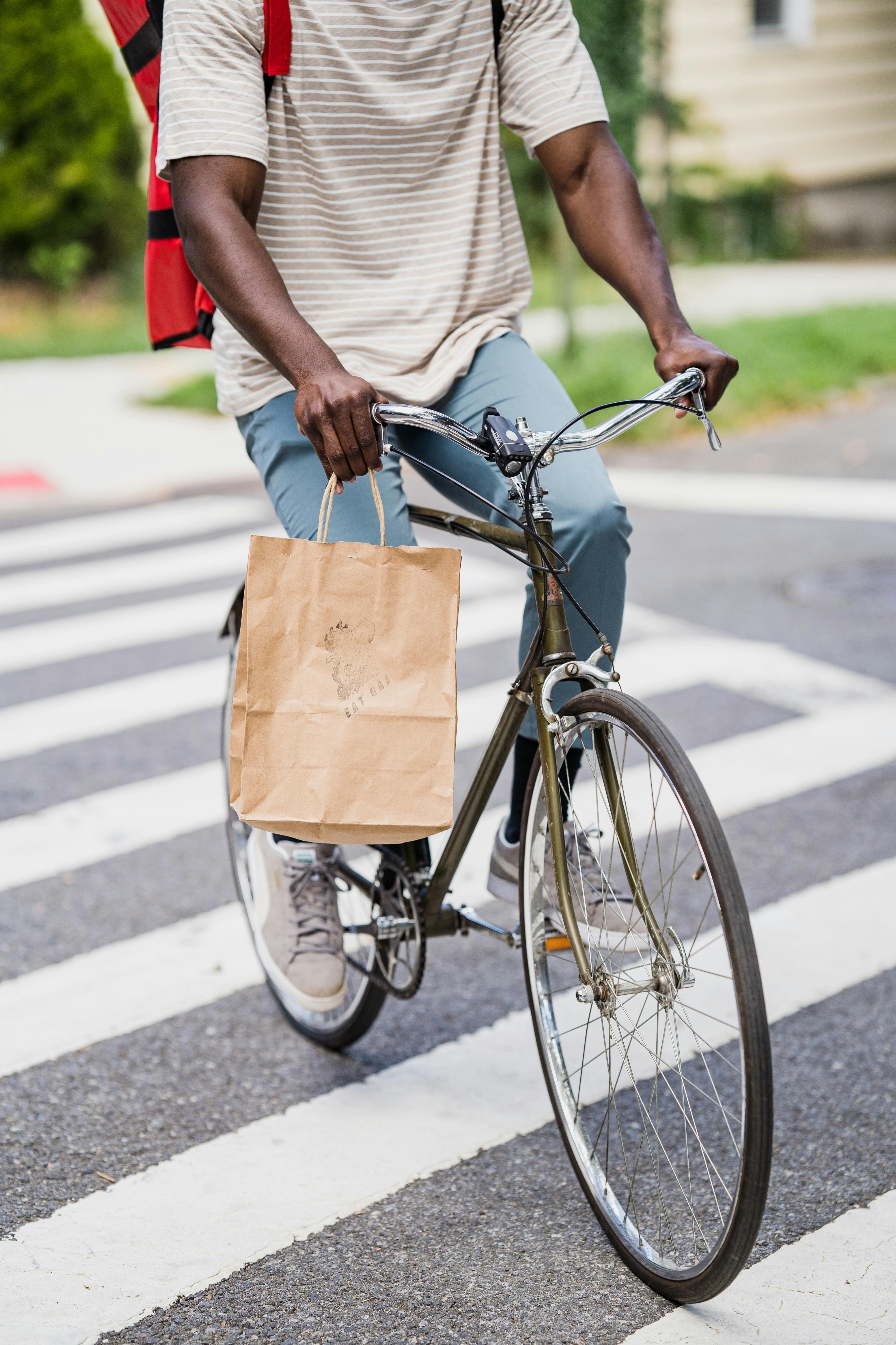 Close-up of Courier Riding Bike on Crosswalk · Free Stock Photo