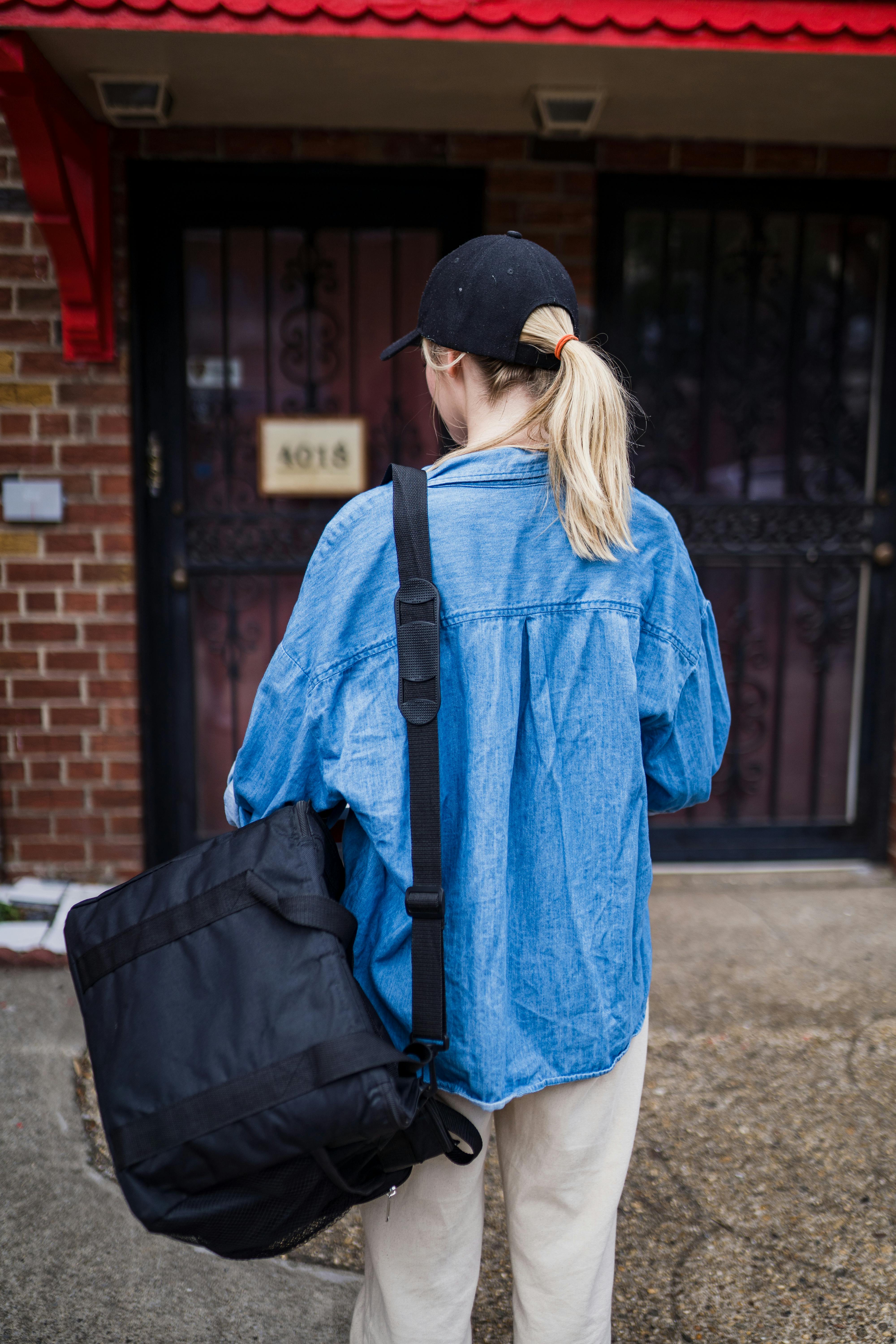 Woman Carrying Bag Standing in front of Door · Free Stock Photo