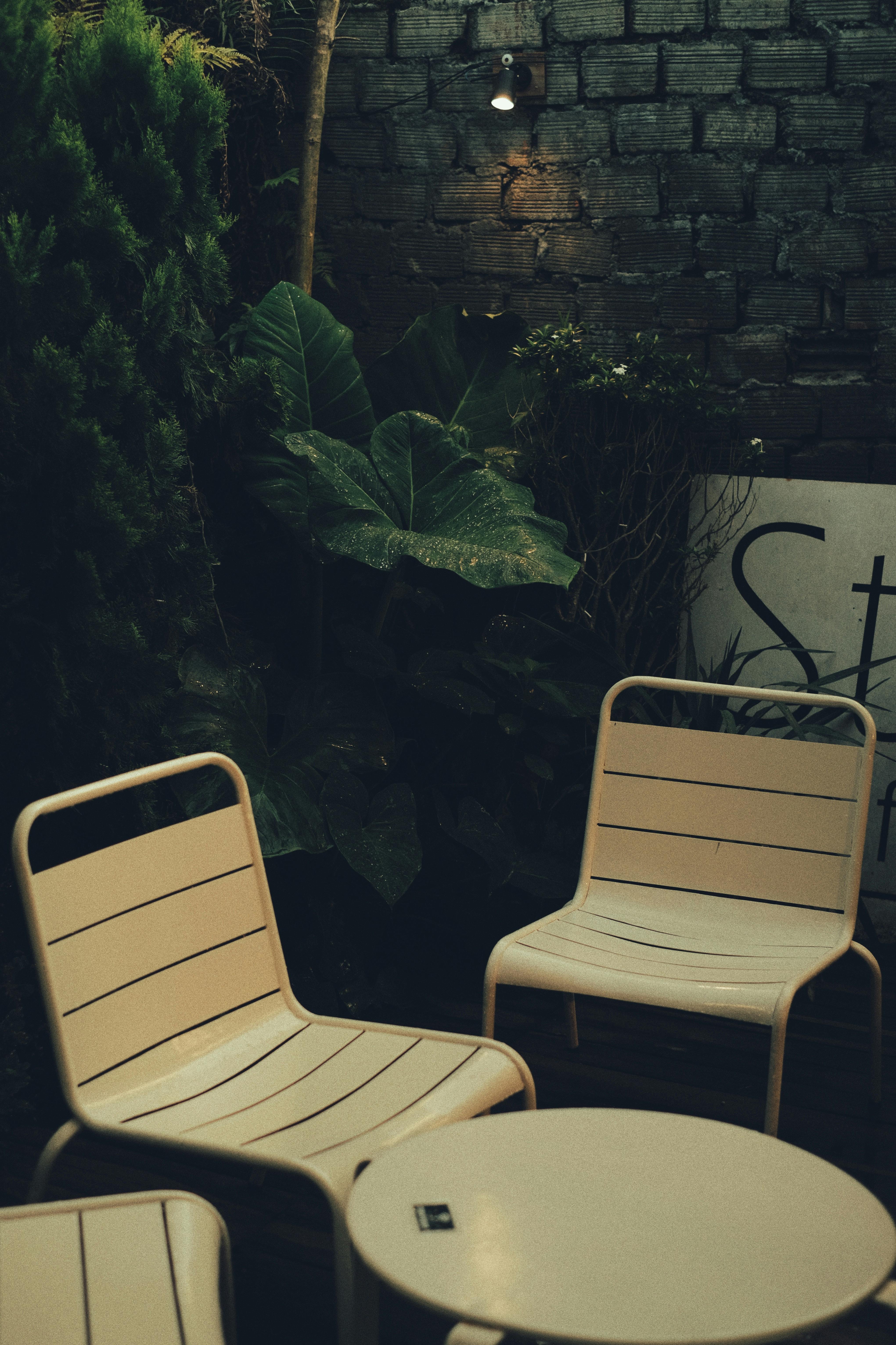 Outdoor Chairs and Table on a Patio with Plants in the Background ...