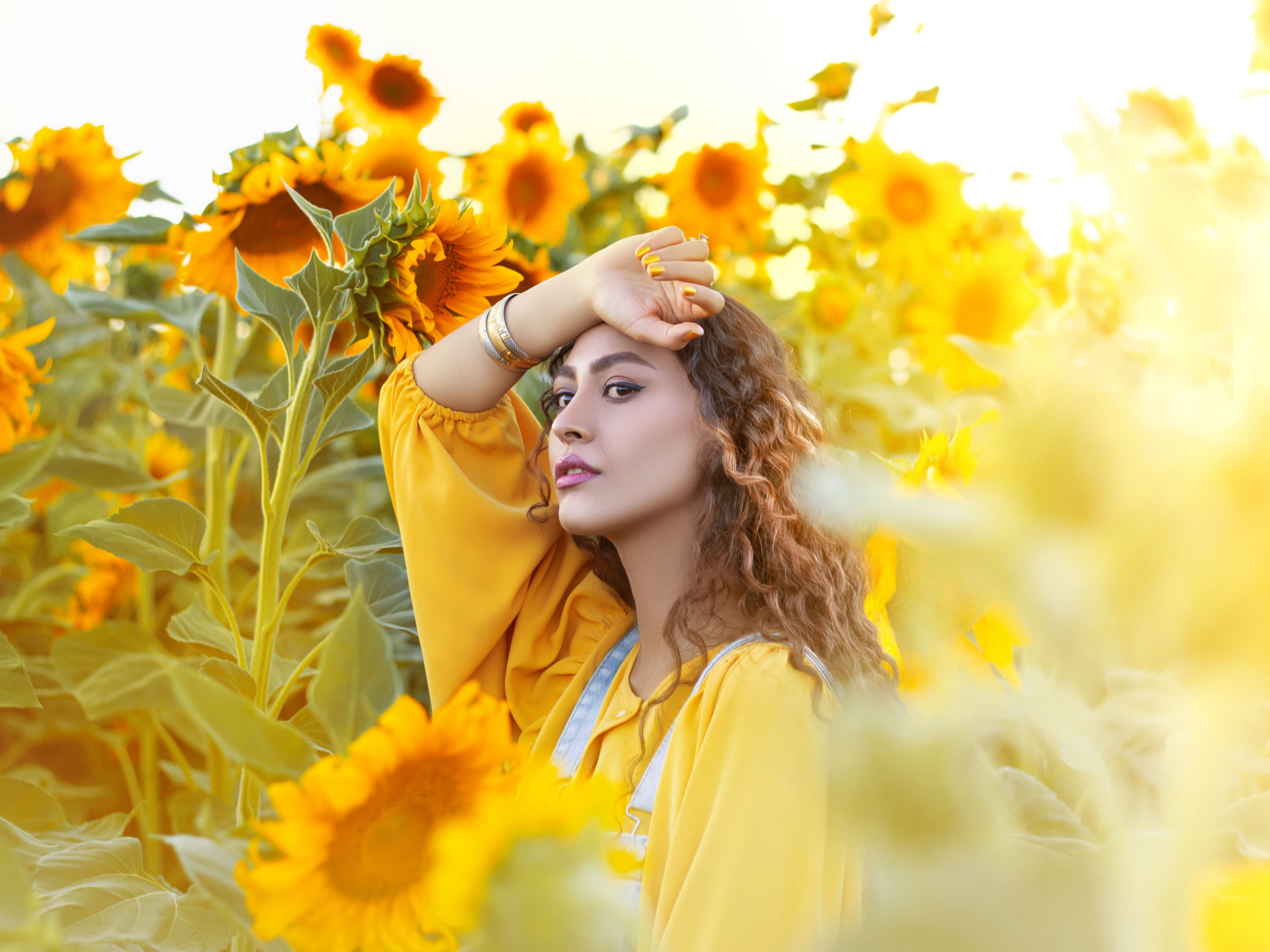 A Woman Wearing a Yellow Dress in a Sunflower Field · Free Stock Photo