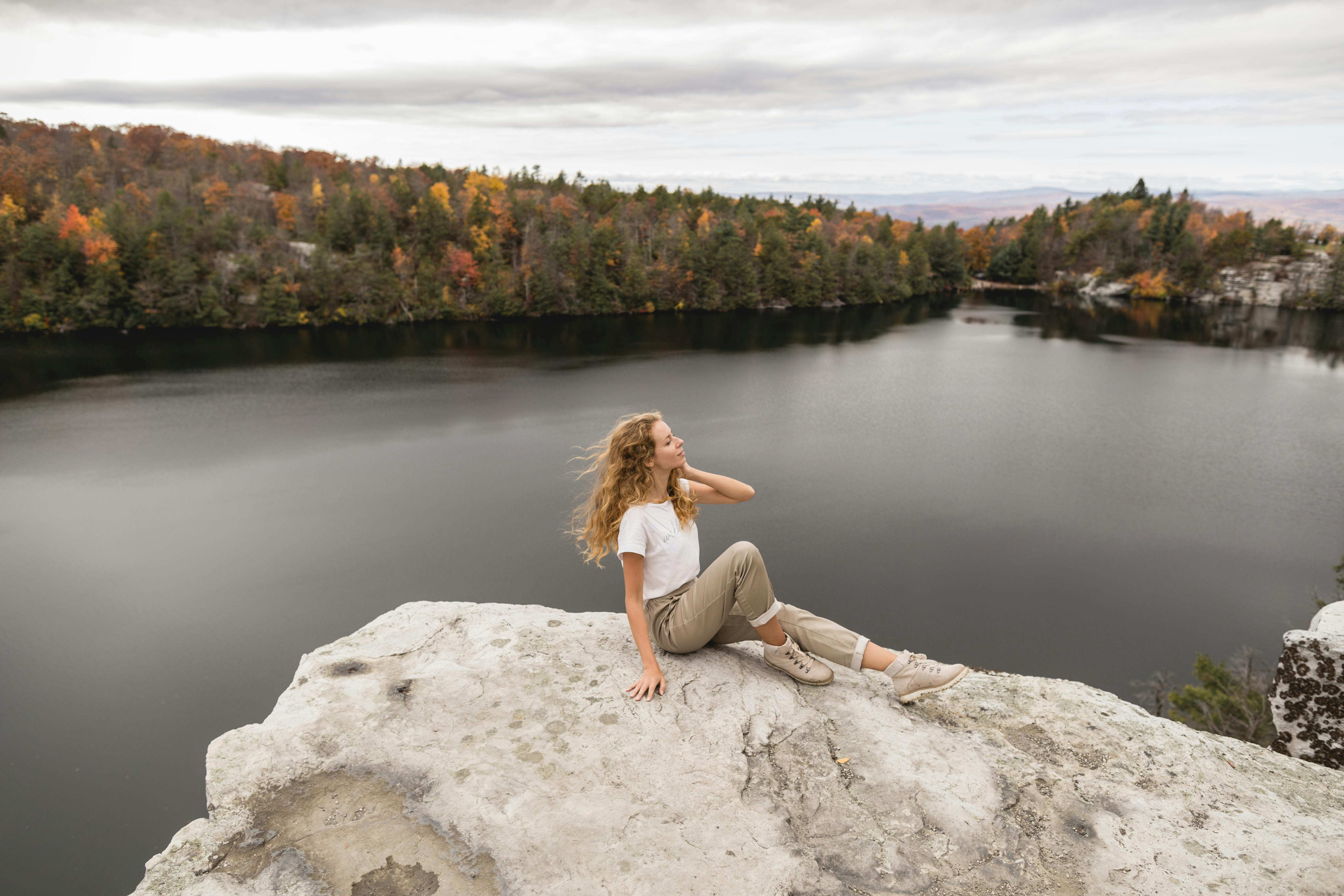 Pretty Woman Sitting on Rock Near the Sea · Free Stock Photo