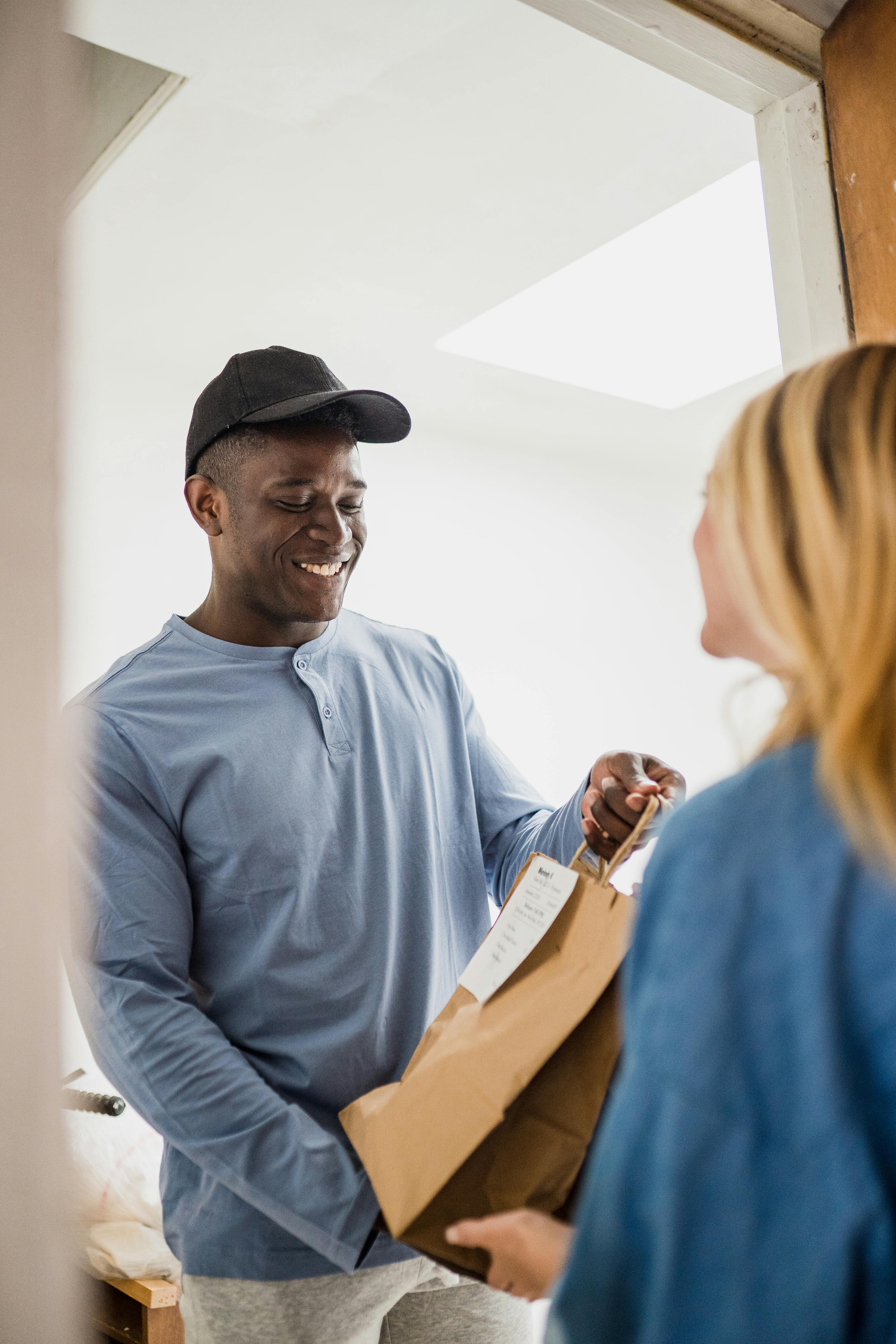Deliveryman with Paper Bag · Free Stock Photo