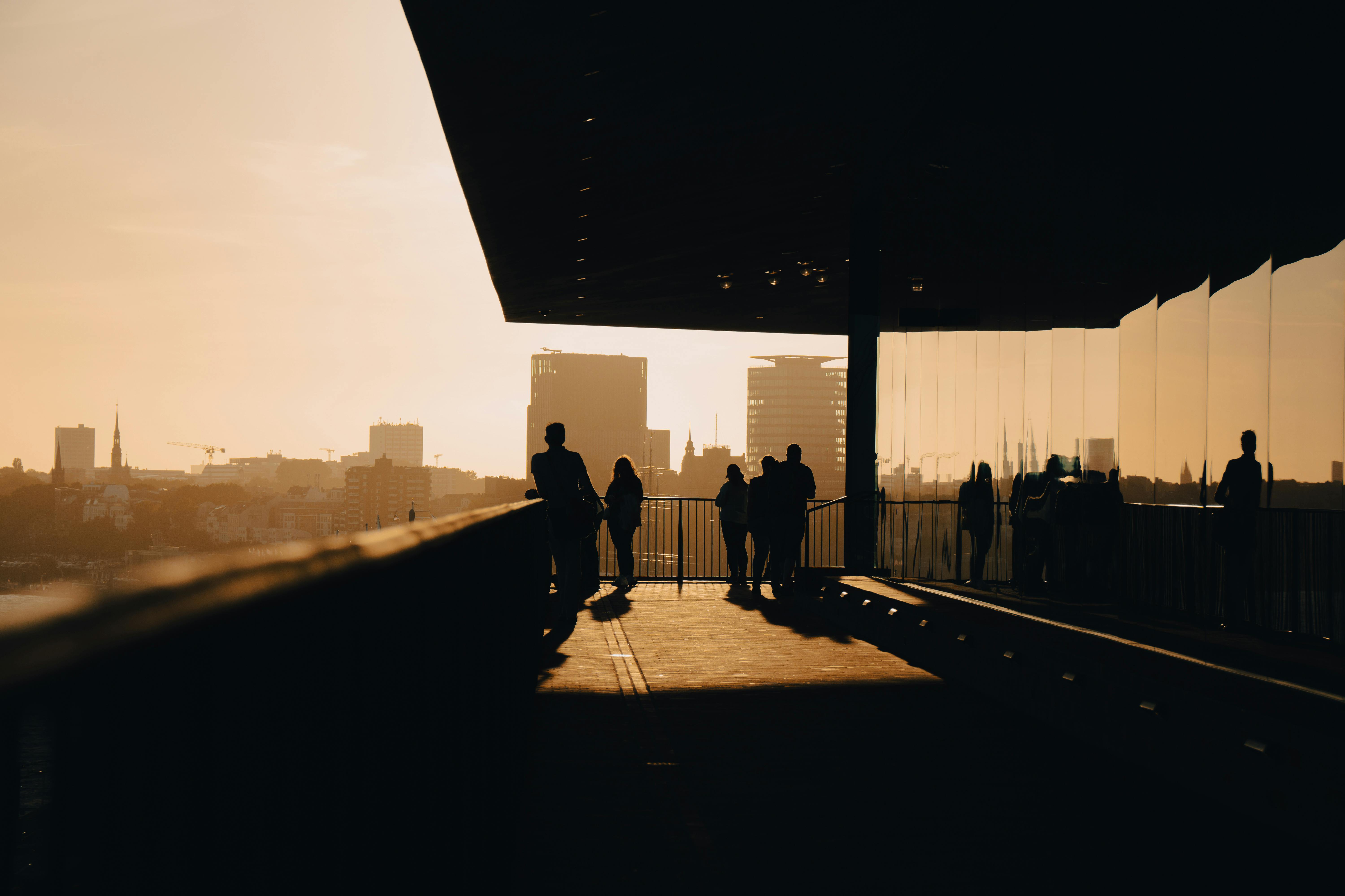 Silhouette of People Standing Outside Glass Building · Free Stock Photo