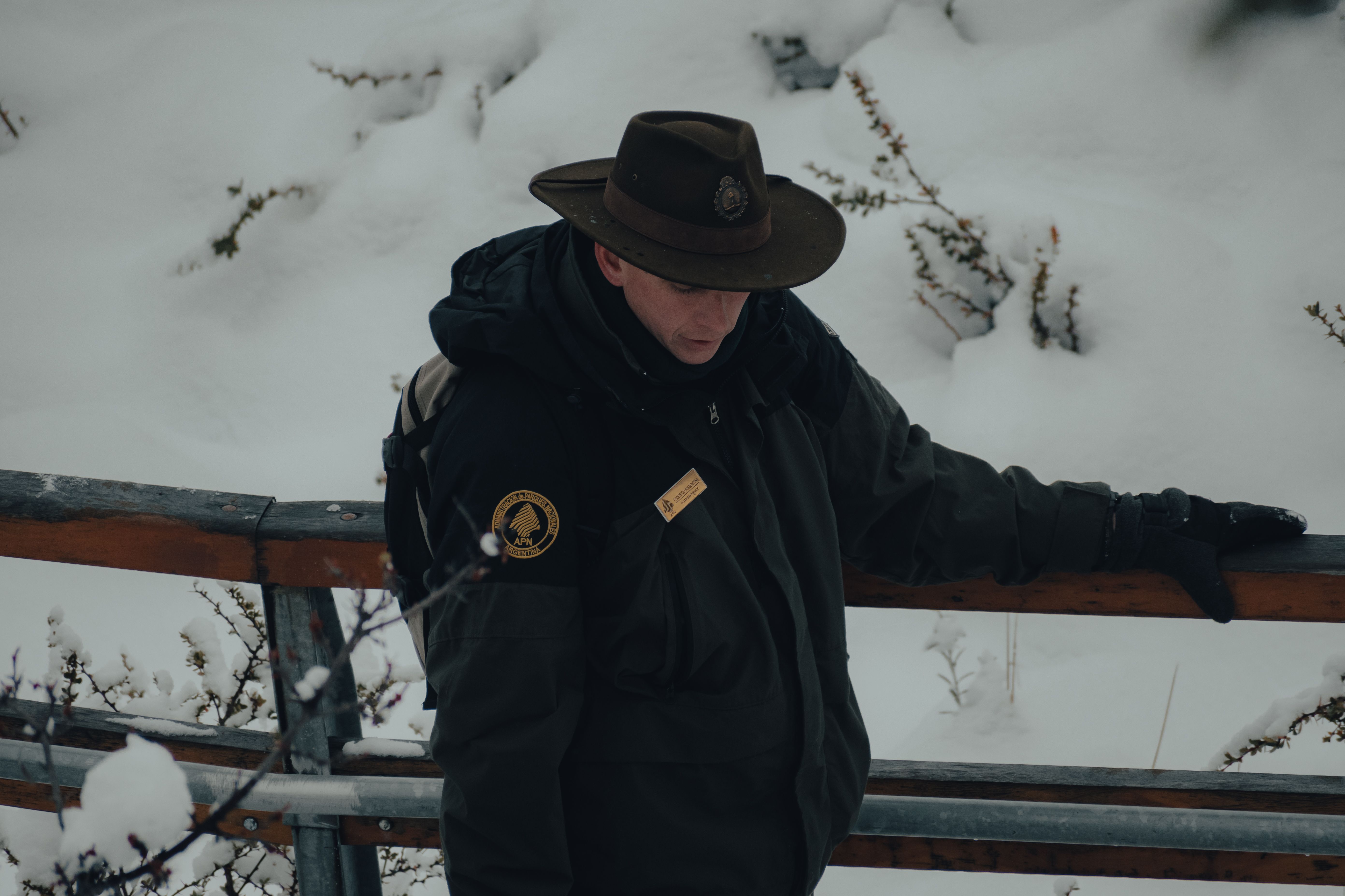 Man in a Winter Jacket and Hat Walking Outdoors in Snow · Free Stock Photo