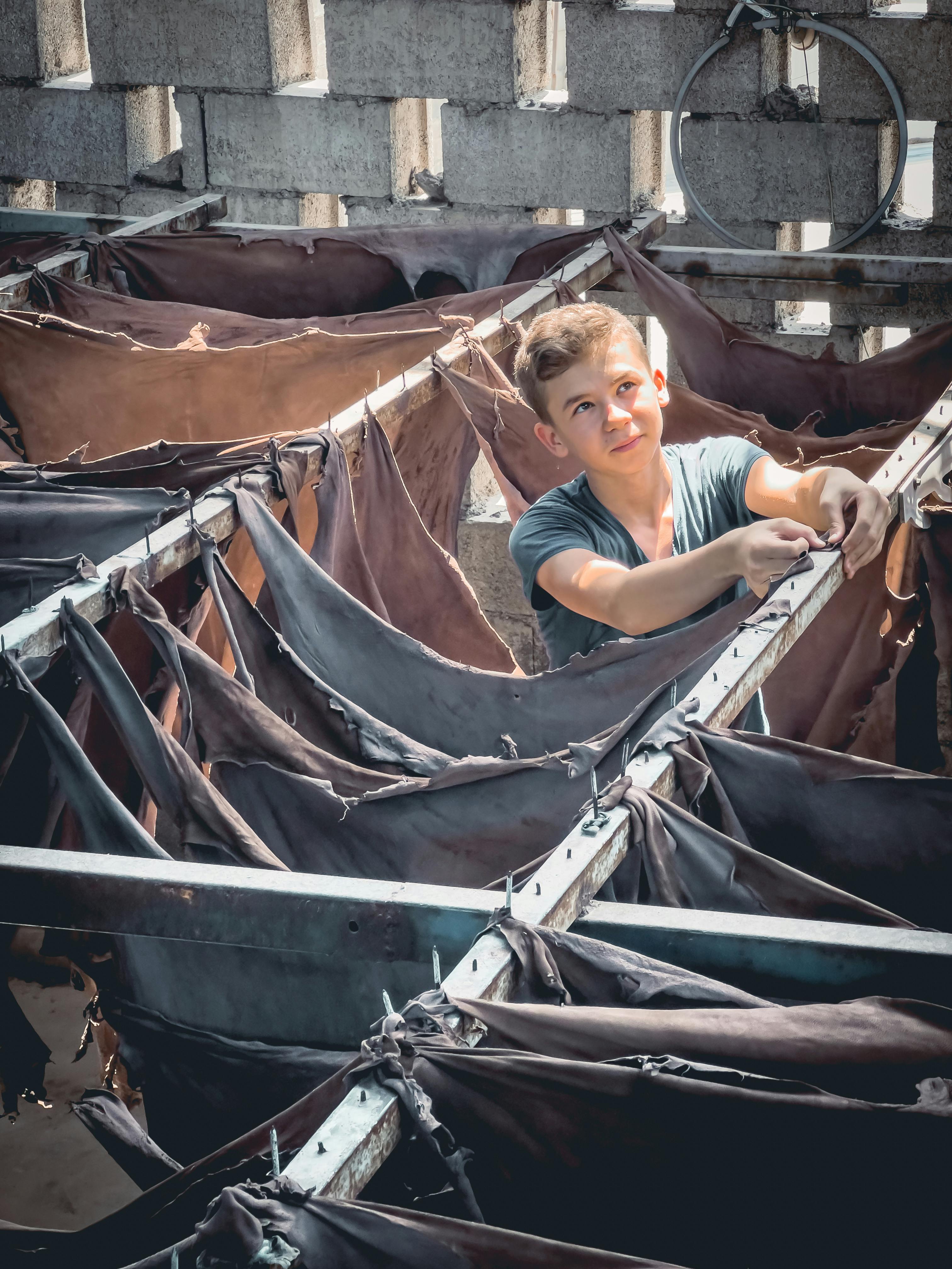 Young Boy Hanging Animal Hide · Free Stock Photo